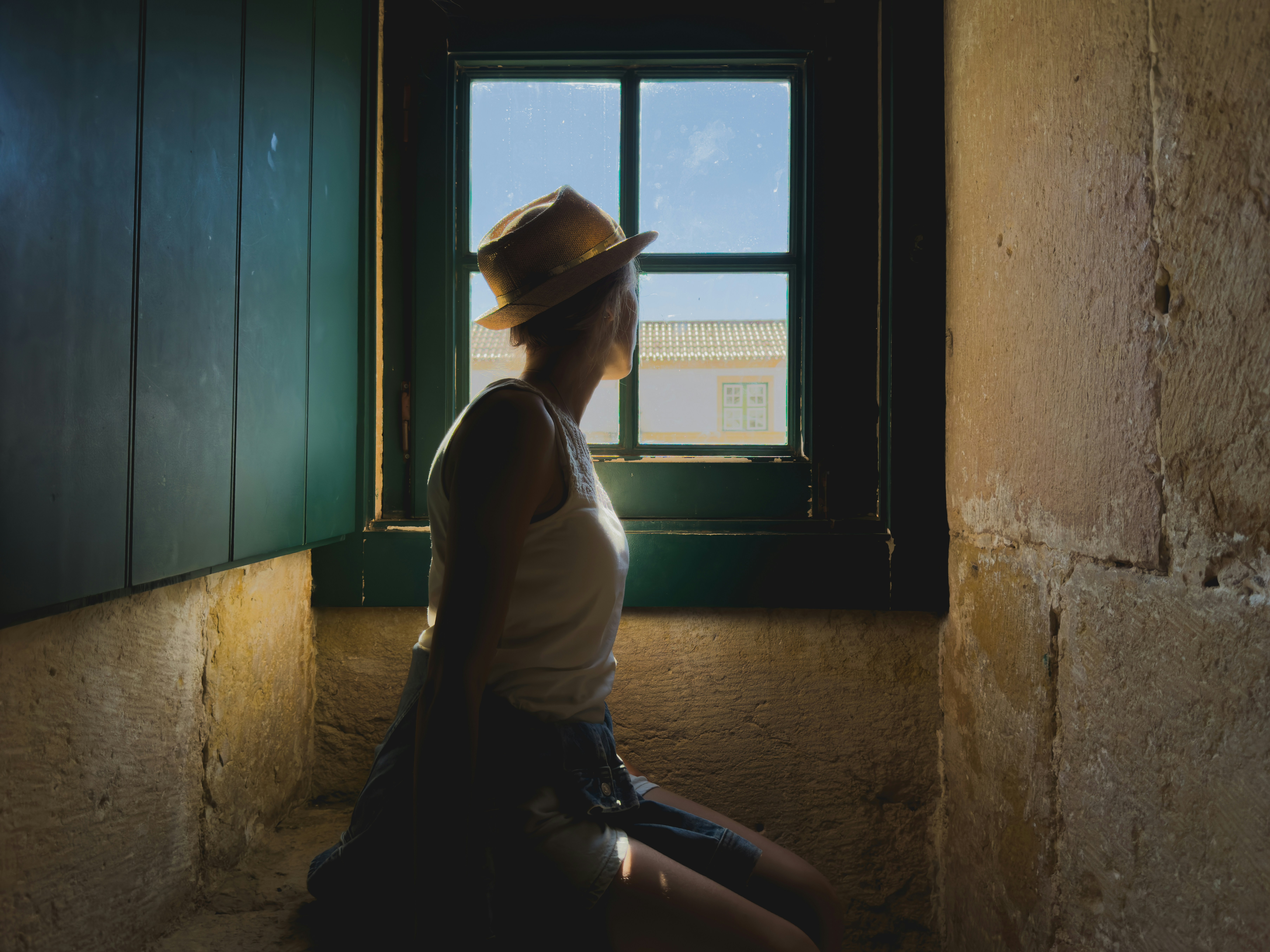 Light at the Window: A Figure in Shadow by the Green Frame