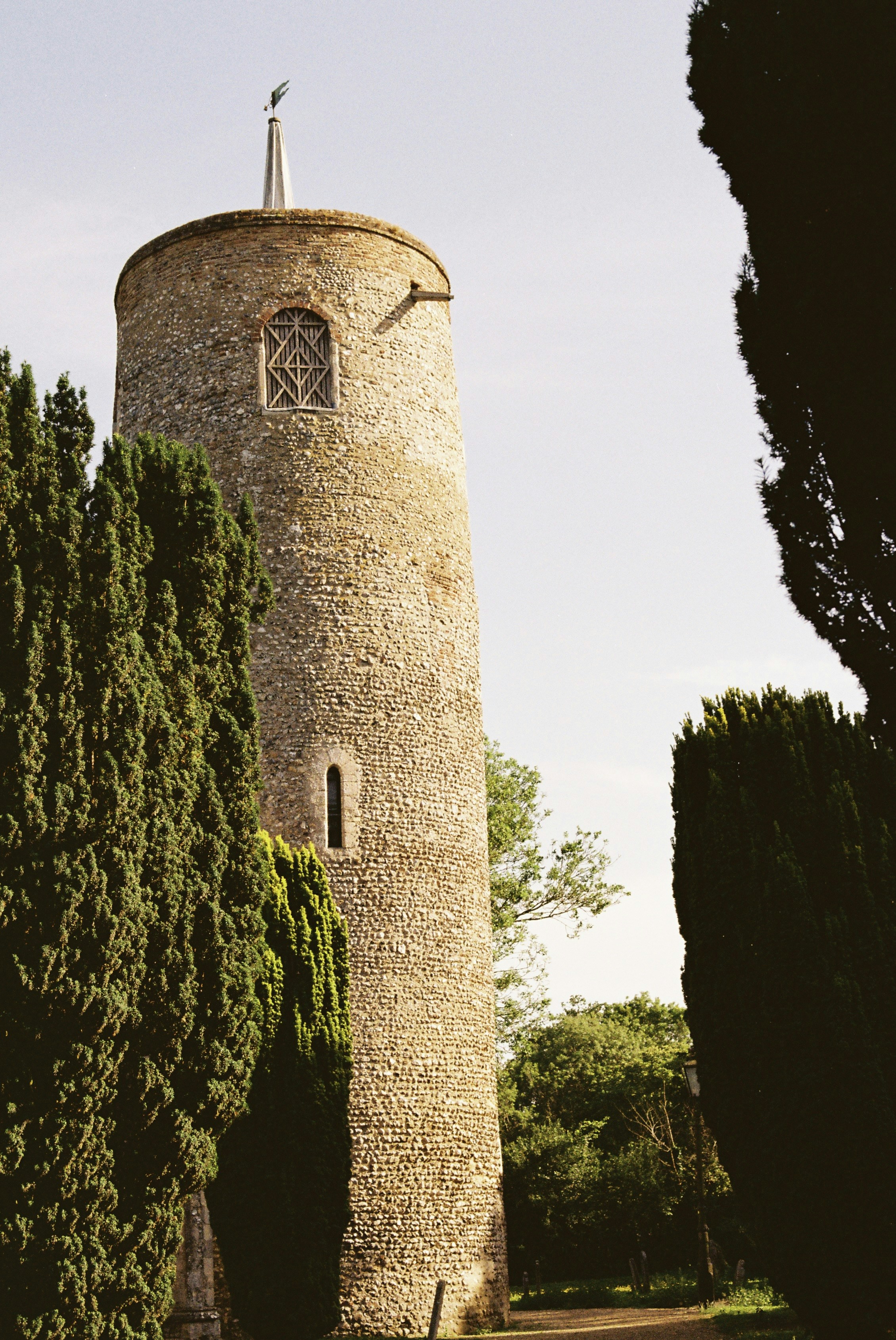 Varied stone tower among towering cypress guardians