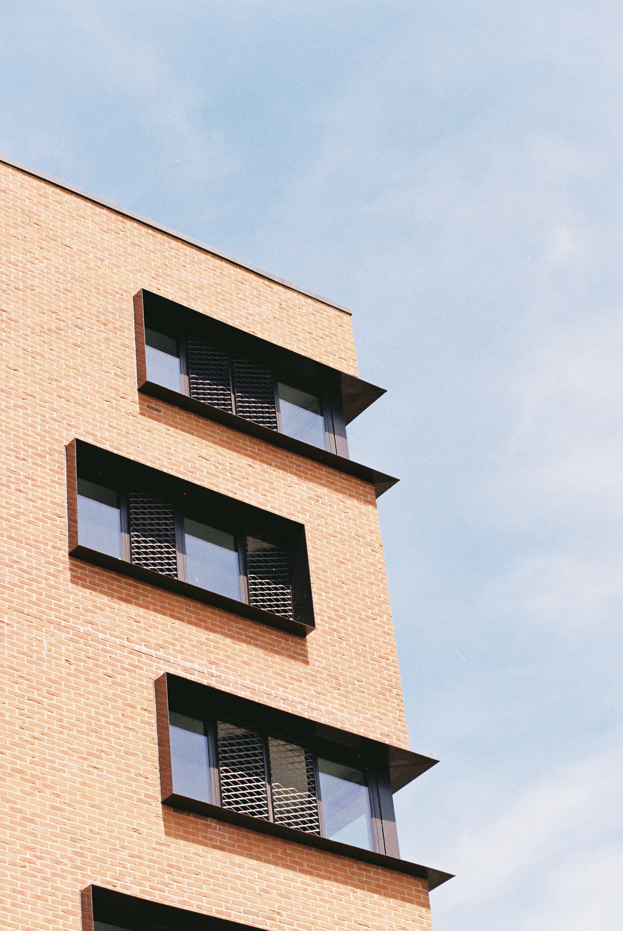 Towering Brick Facade: A Layered Street of Windows Against a Clear Sky