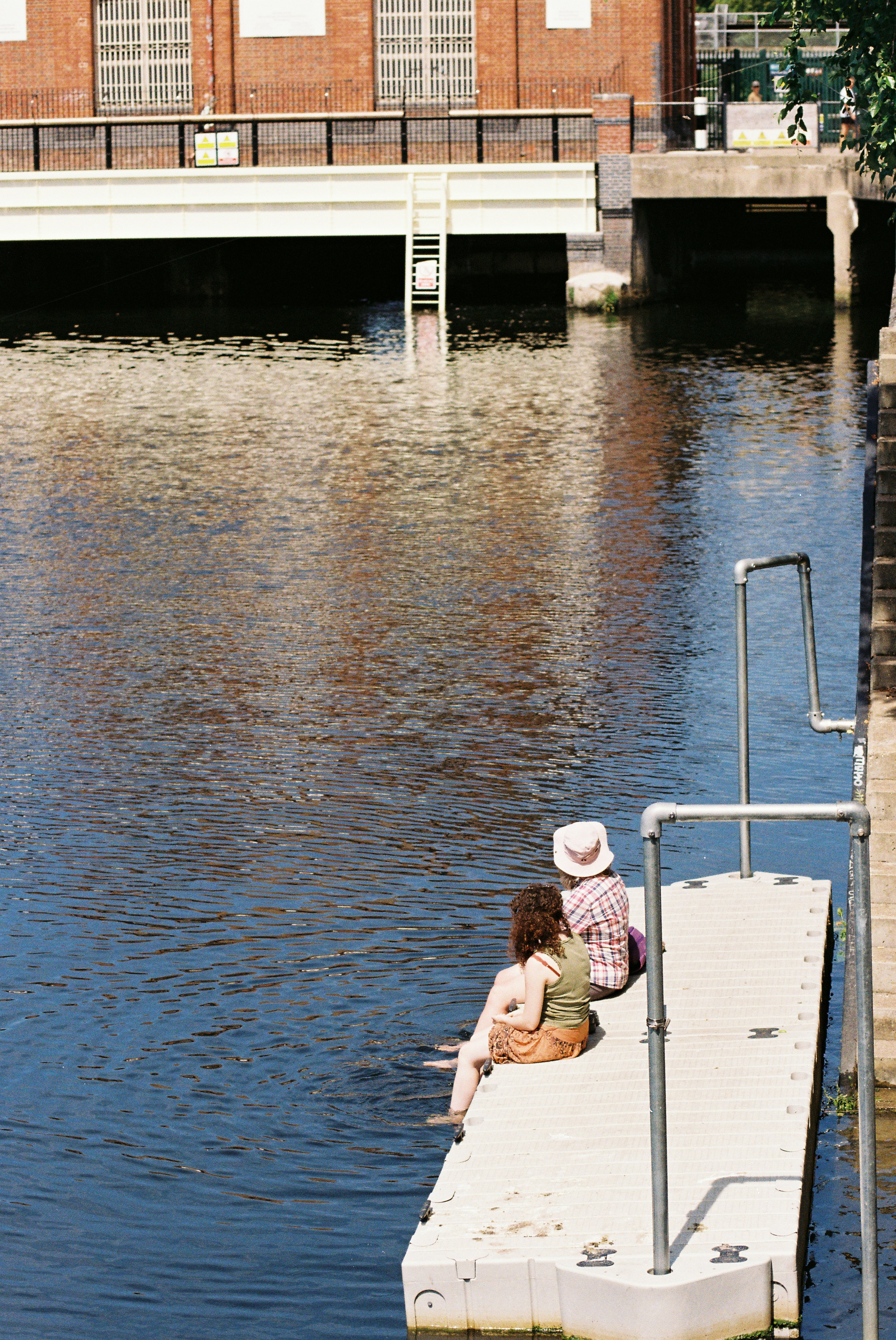 Quiet Riverside Dock: Two Figures Gazing Toward the Water