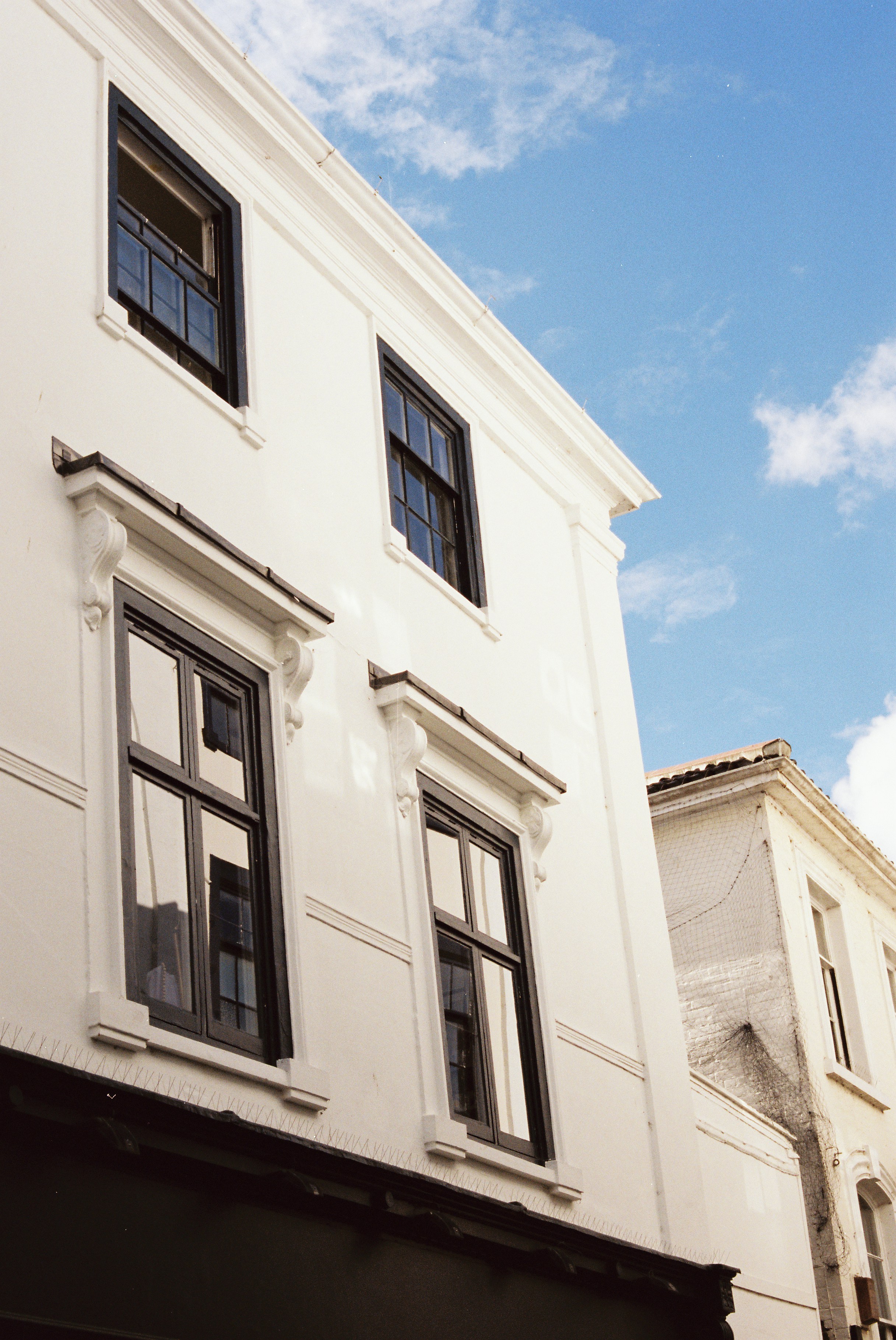 Architectural Portrait: White Facade Beneath a Bright Sky