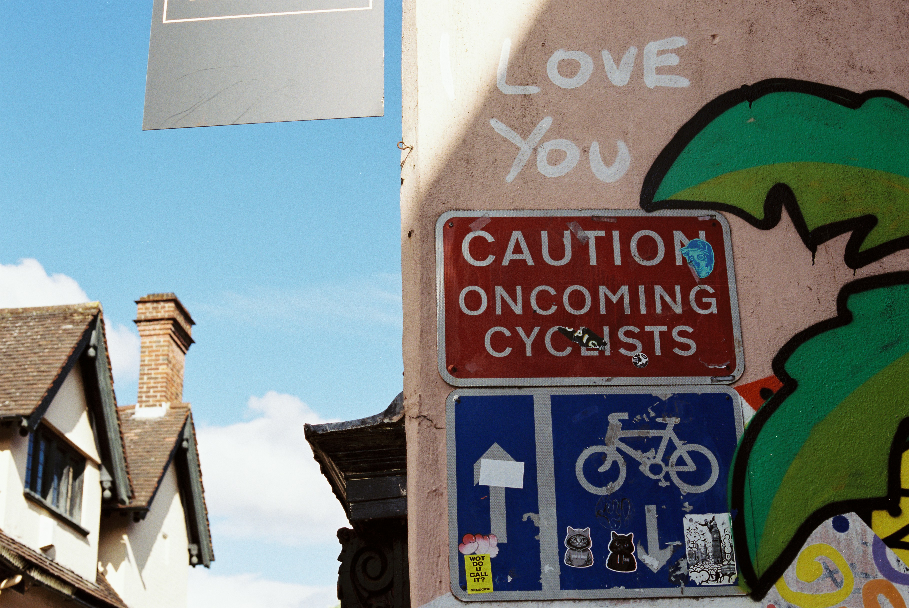A graffiti-painted wall with cycle signs and a hand-scrawled 'I love you' stands against blue sky.