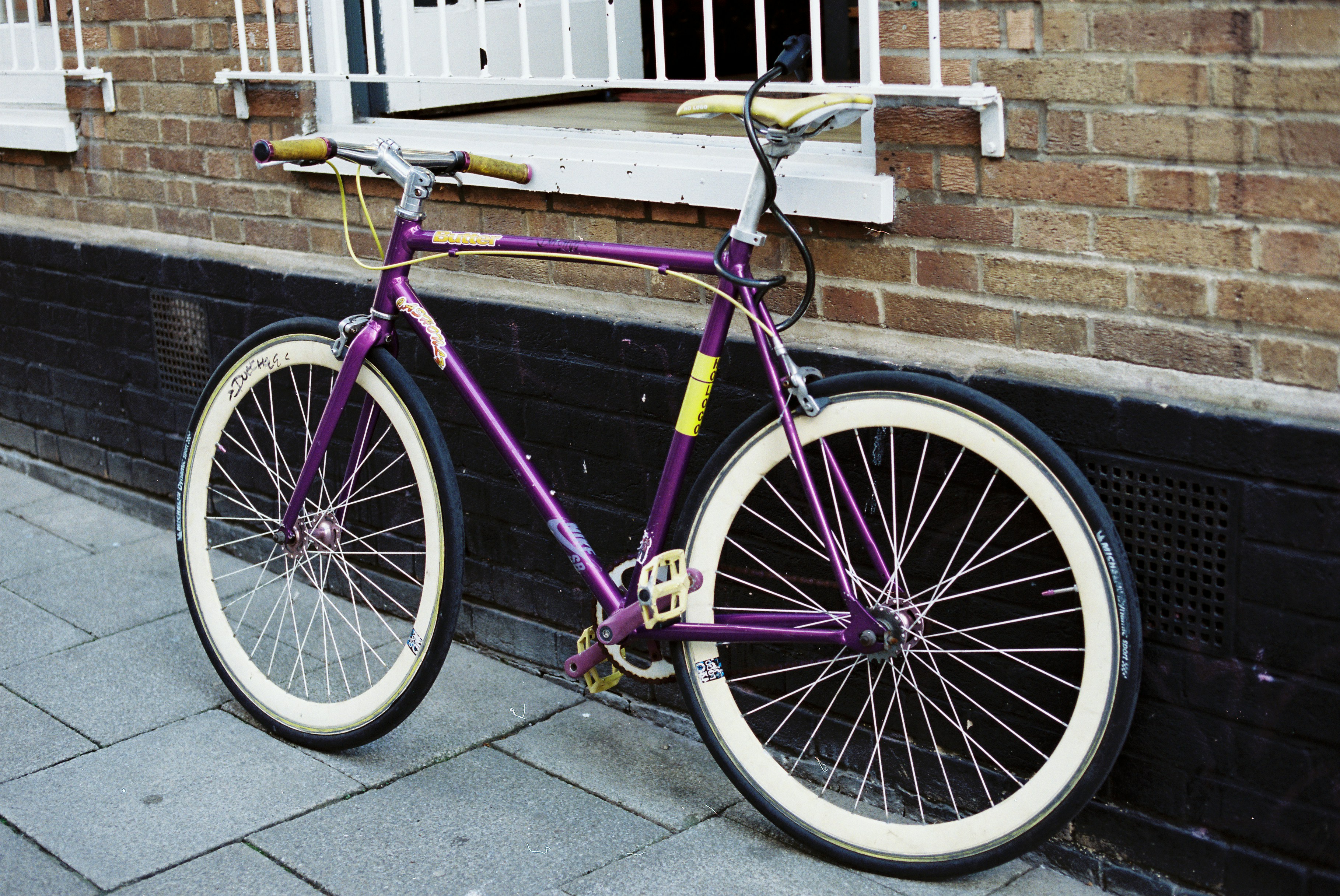 Lavender Ride: A Purple Bicycle Resting Against a Brick Wall