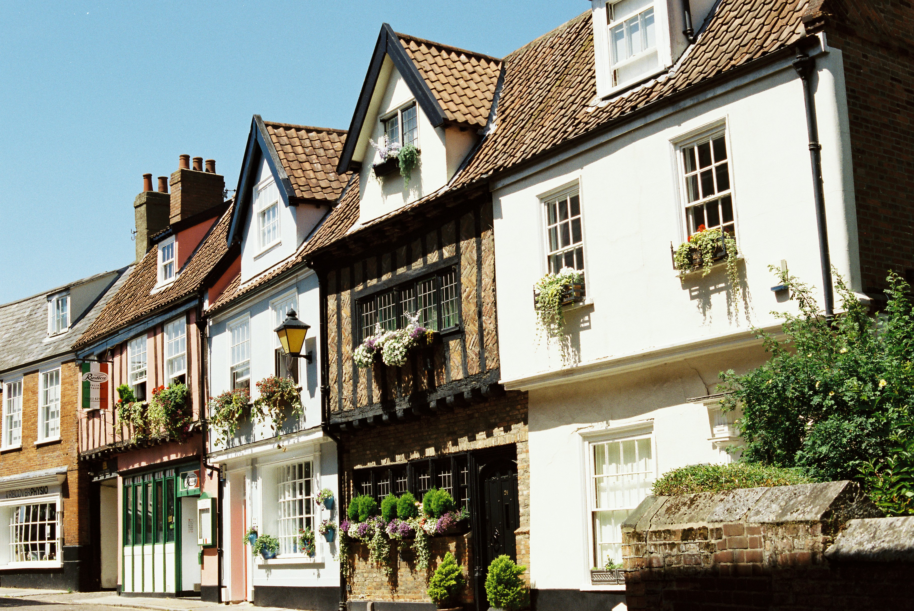 Row of Tudor-Style Townhouses under a Bright Summer Sky