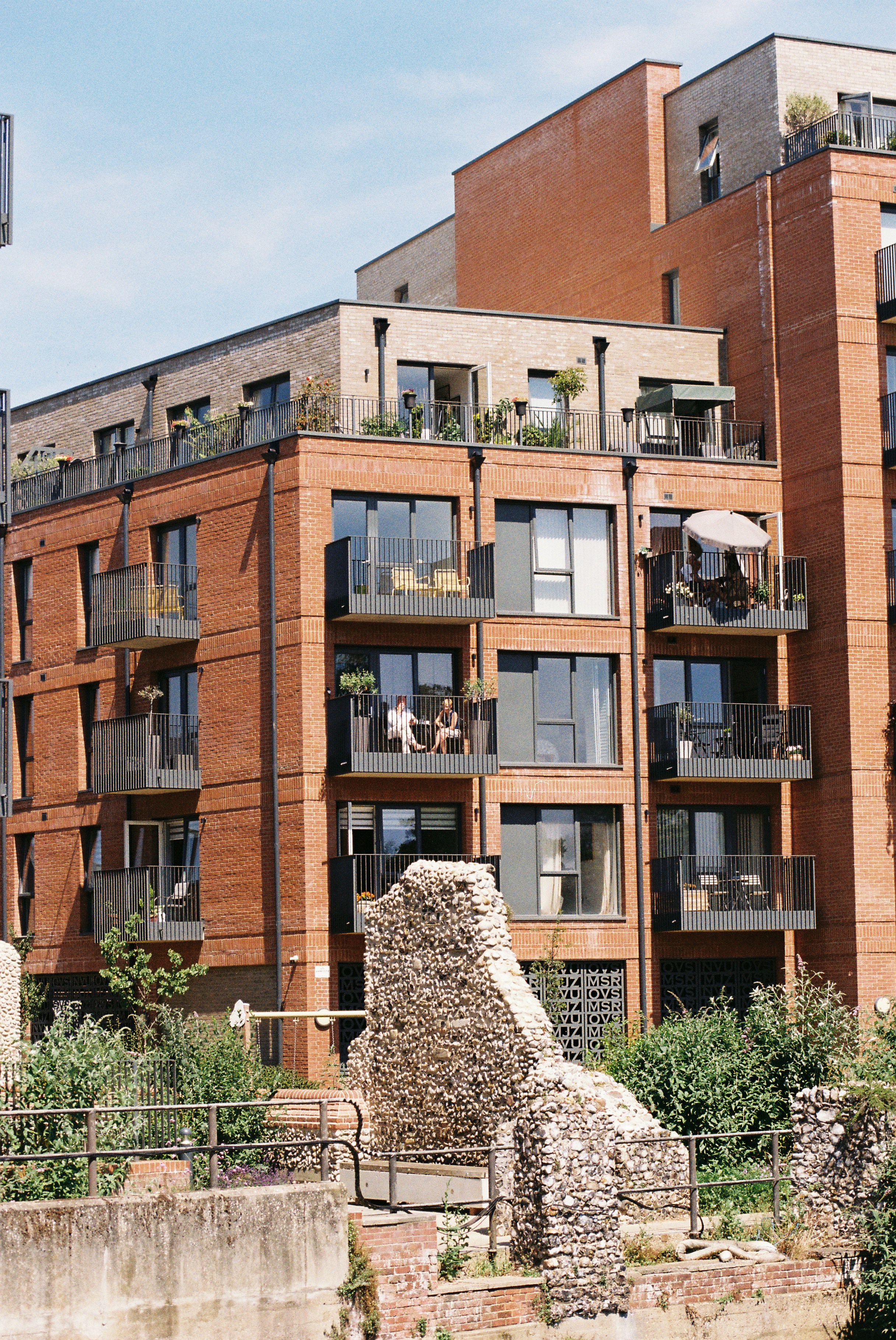 Brick-resolved courtyard living: balconies and remnants of a public sculpture