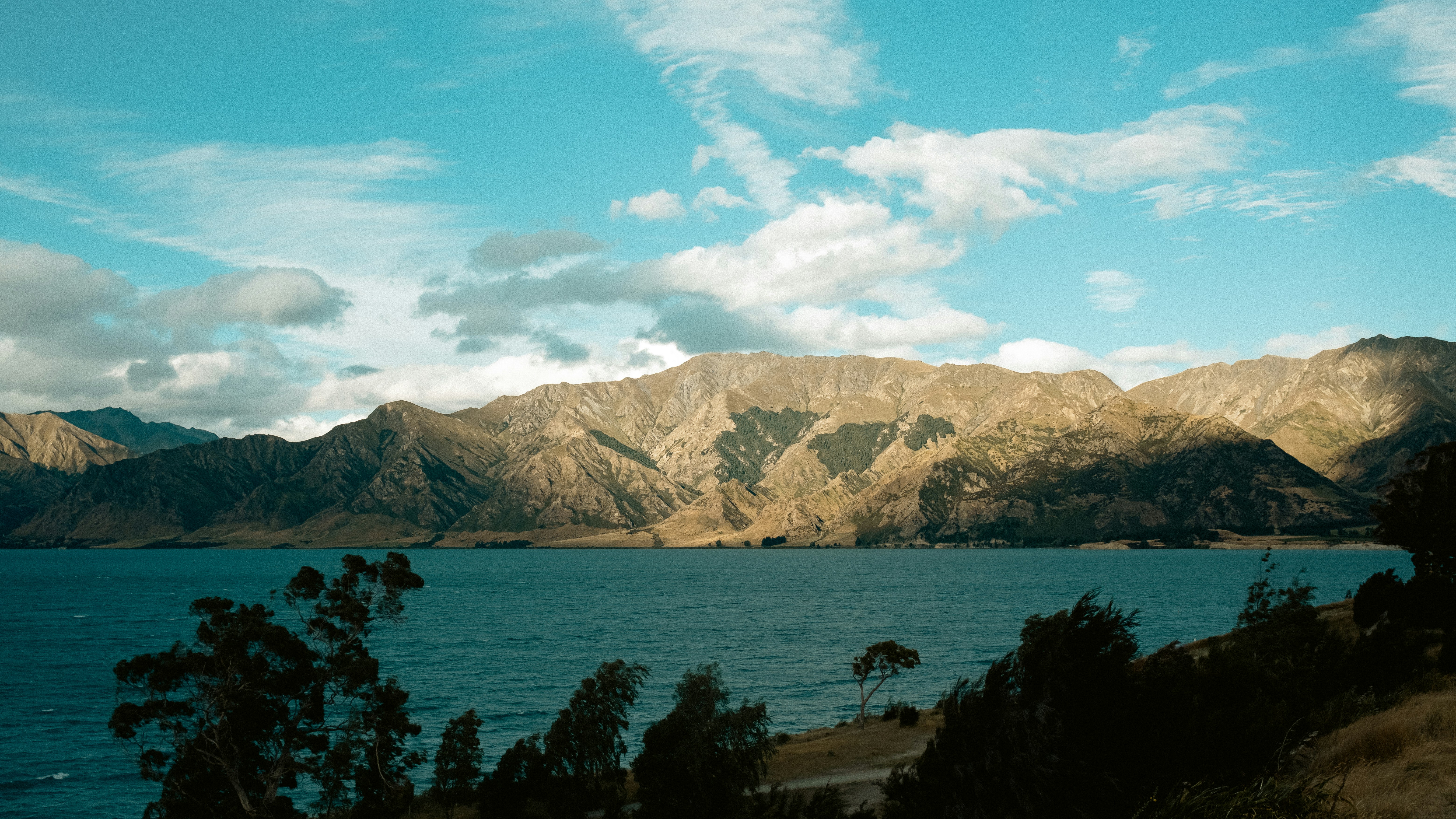 Shoreline Silence: Mountains Framing a Calm Coastal Span