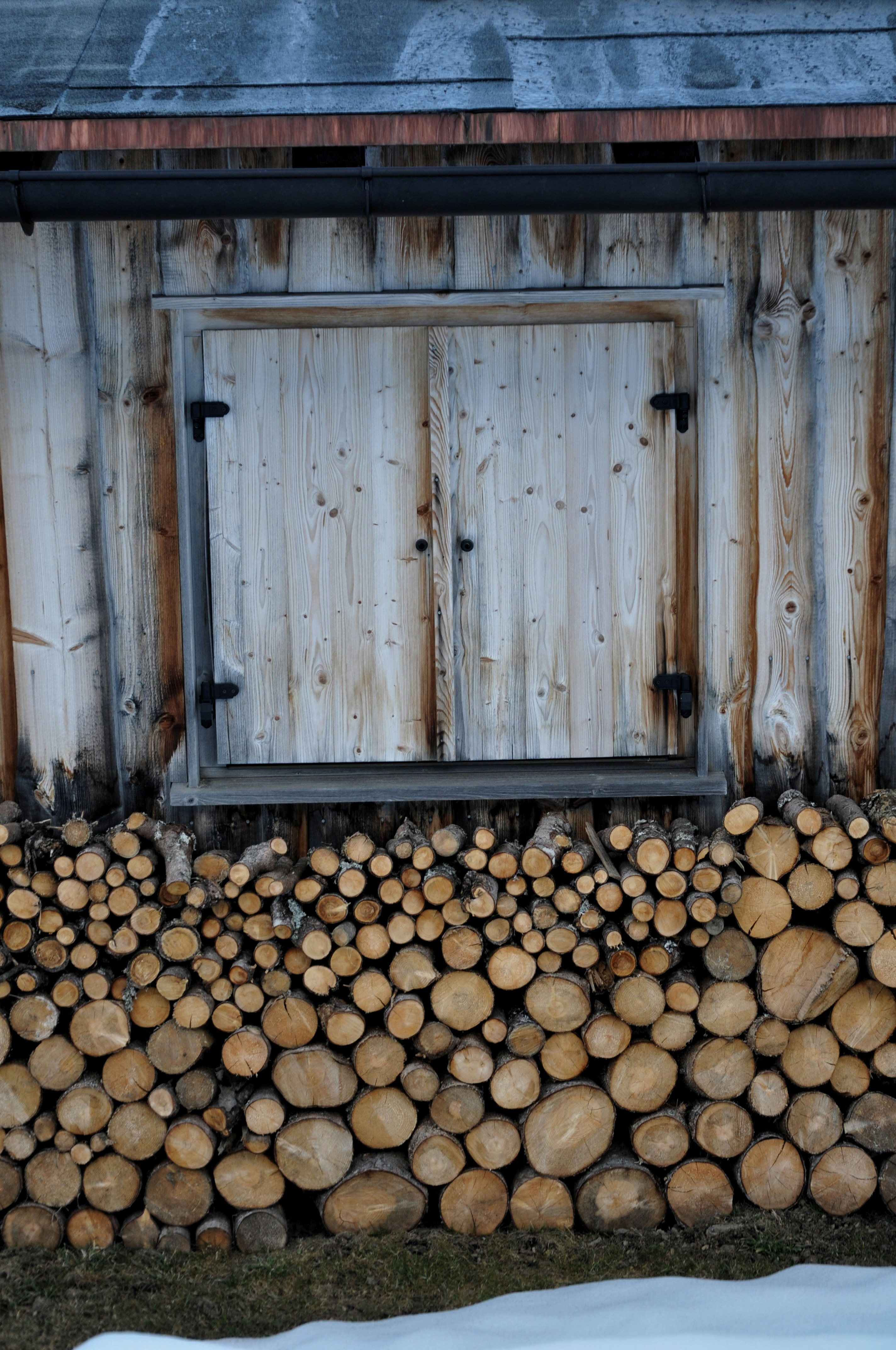 Weathered Timber Gate Above a Tidy Stack of Firewood
