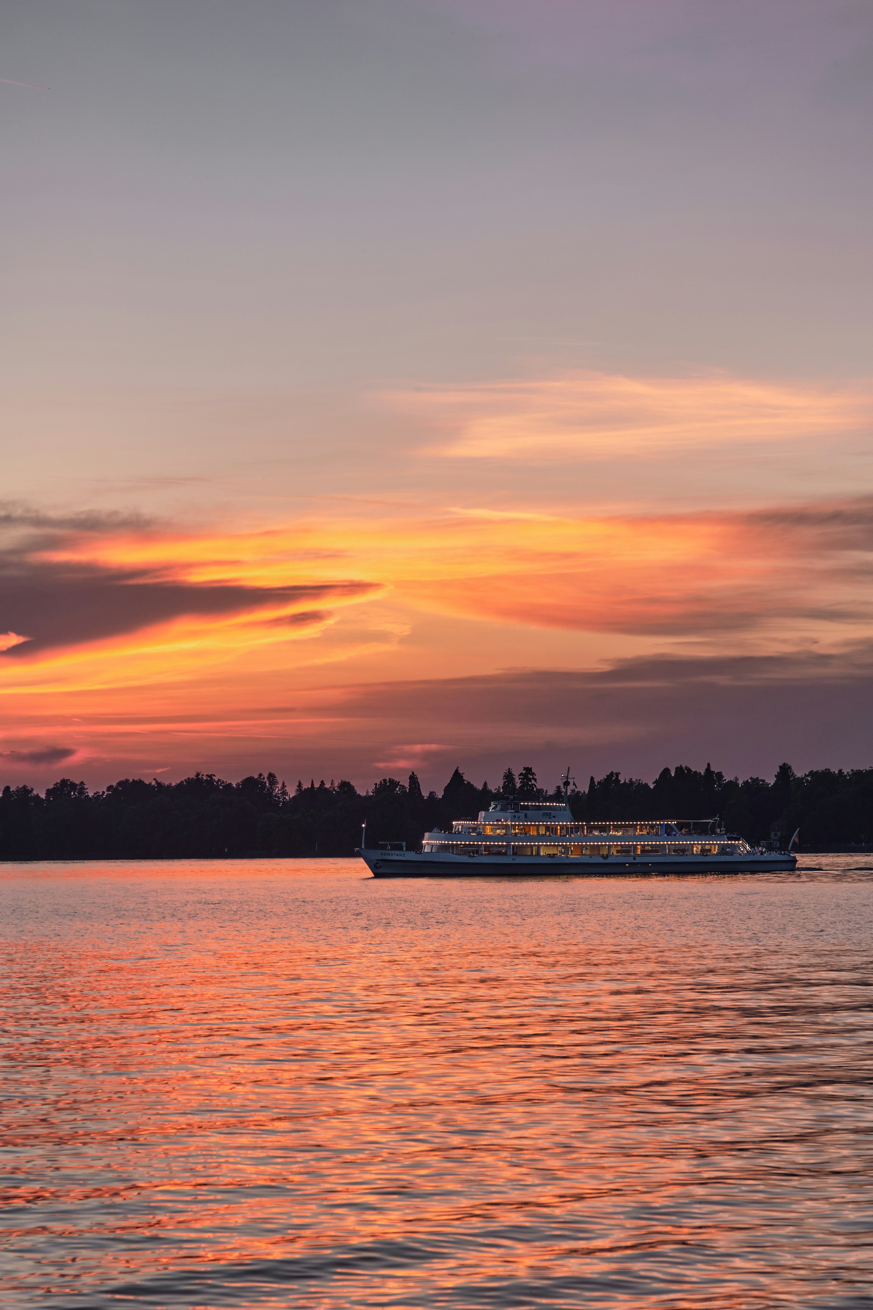 Sunset Vessel: A Quiet Ferry Traverses a Glowing Lake