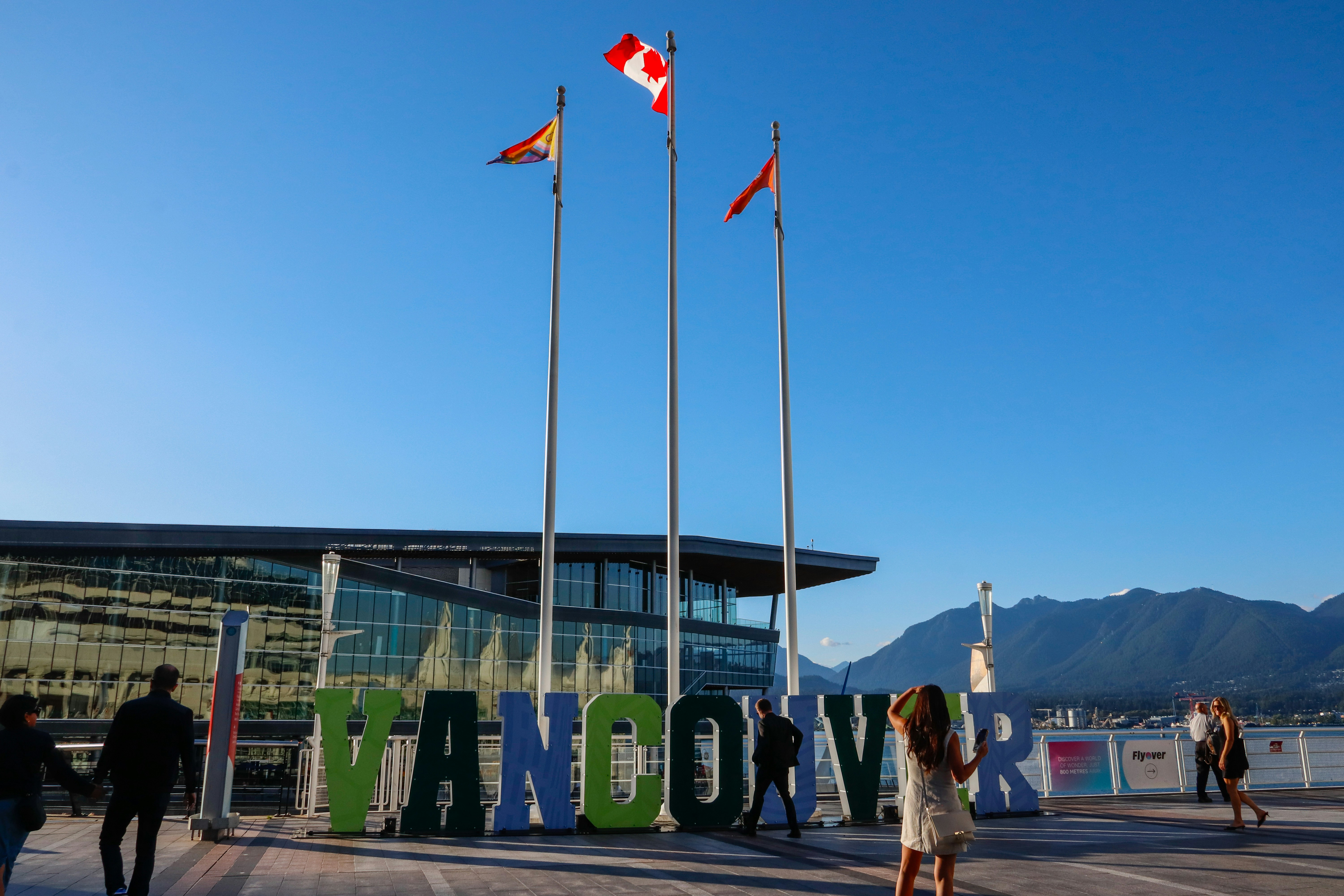 Vancouver Verve: City Letters and Flagpoles under a Clear Sky