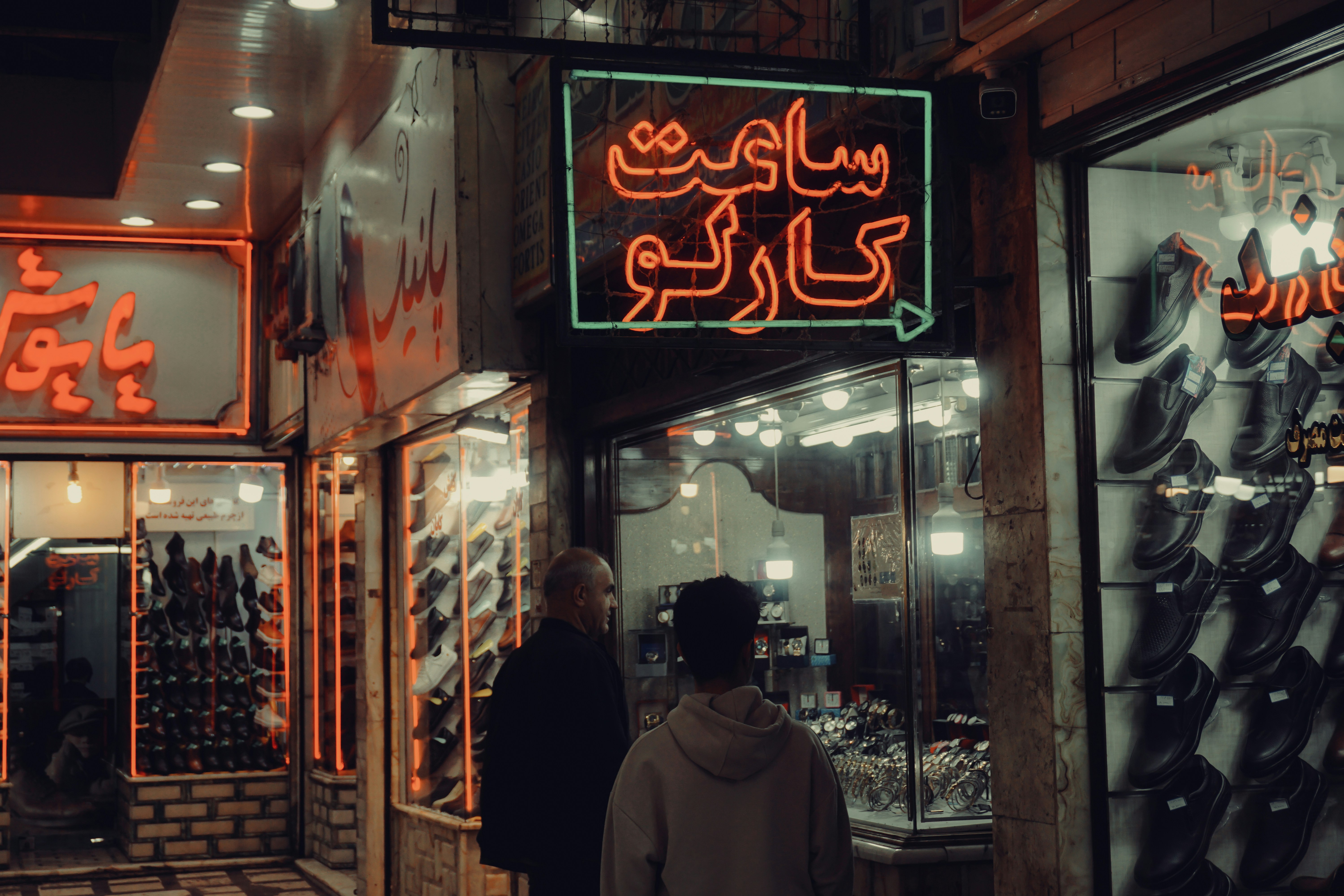 Neon Sign in the Night Market: A Glimpse Through Glass