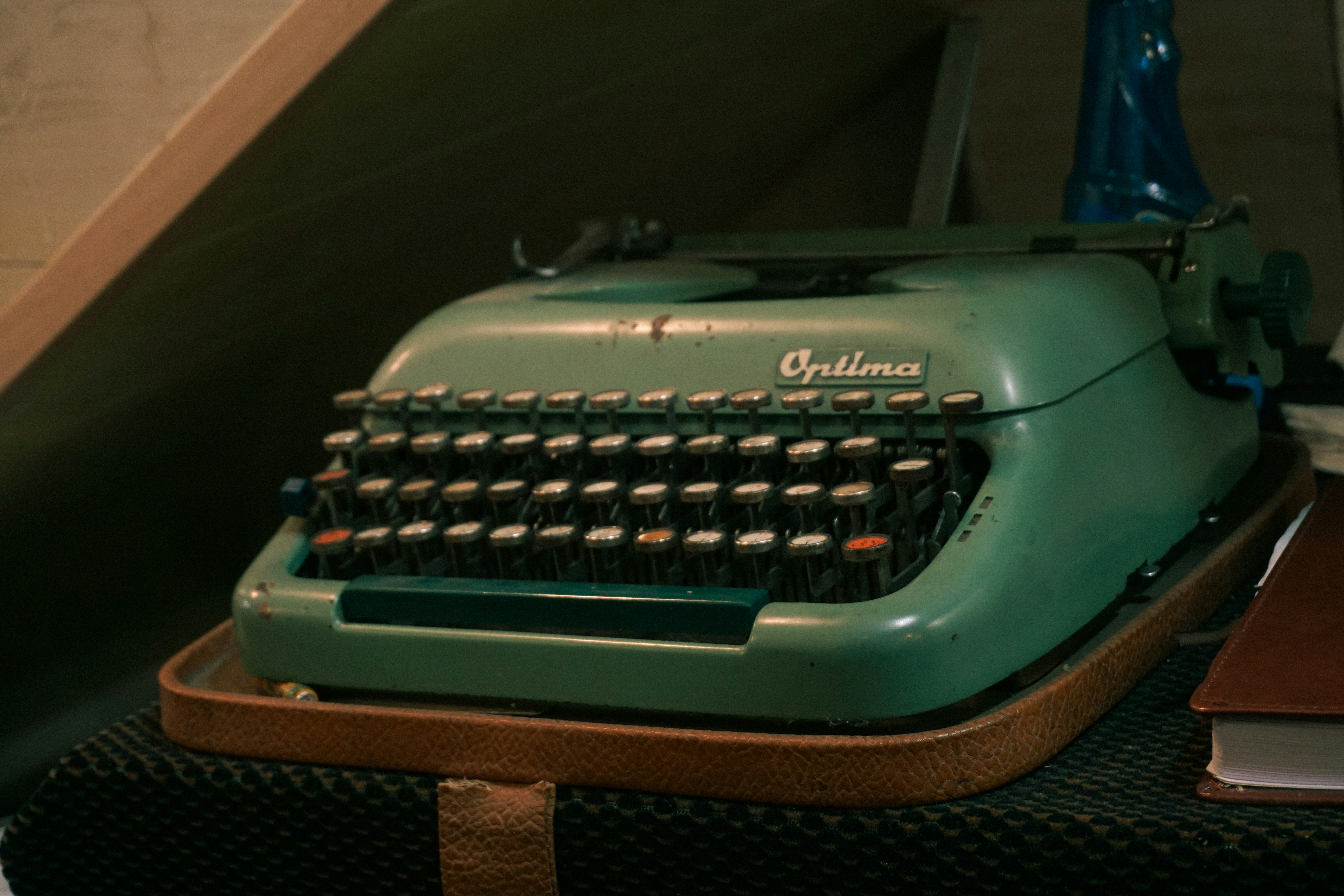 Turquoise Vintage Typewriter Resting Under Soft Shadow