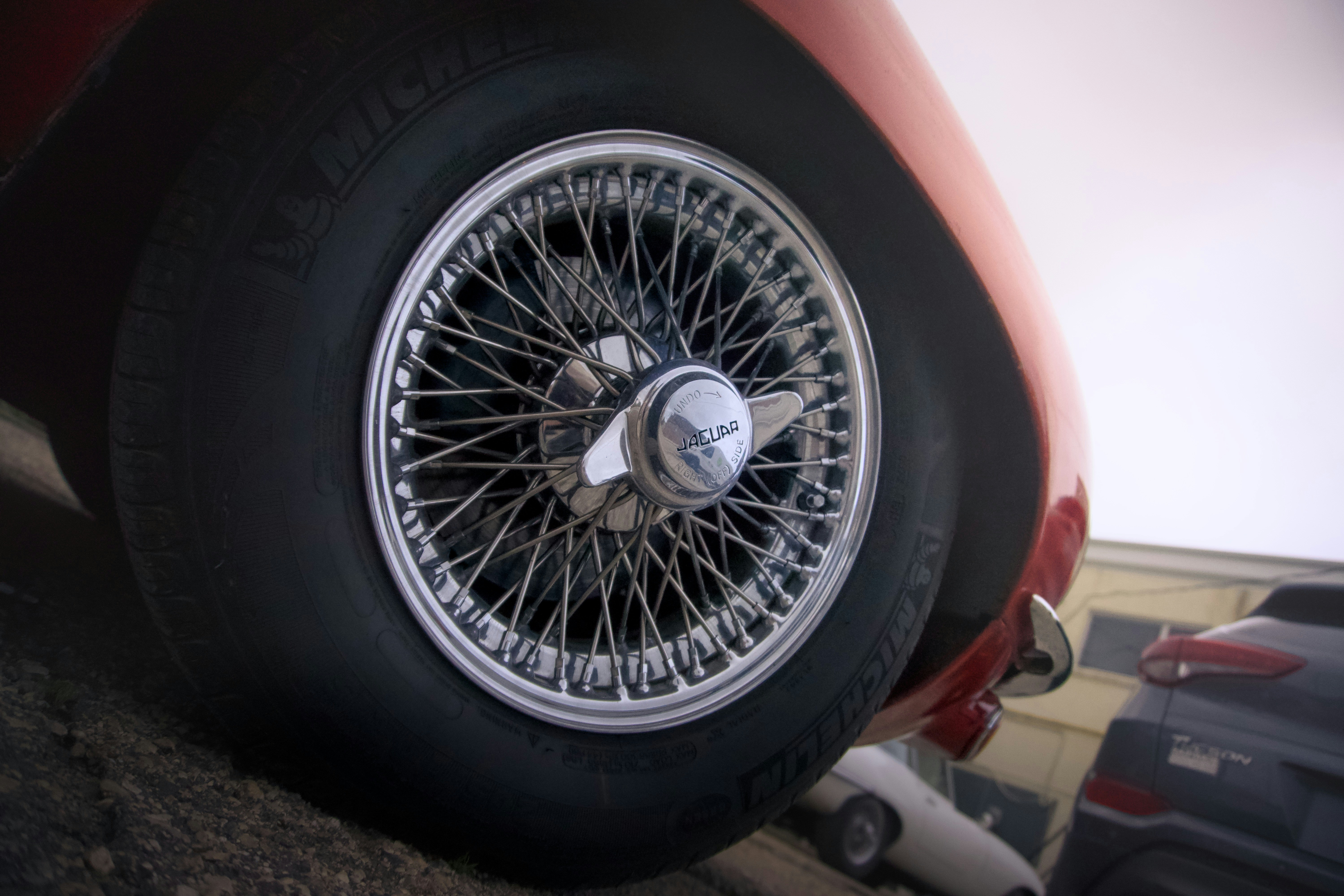 Close-up of a classic wire-wheel car with a chrome hubcap