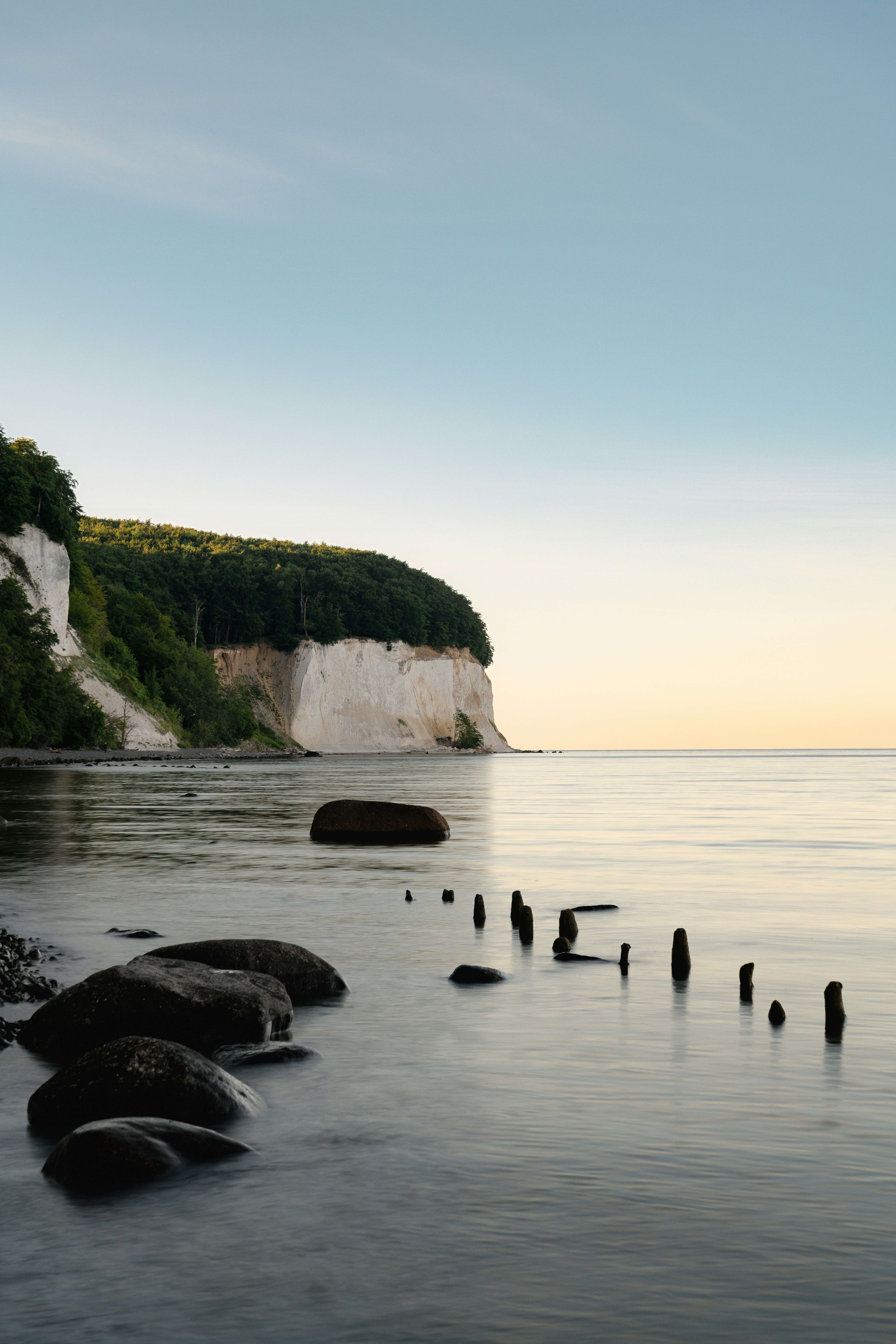 White Cliffs at Dusk: Calm Sea, Weathered Posts