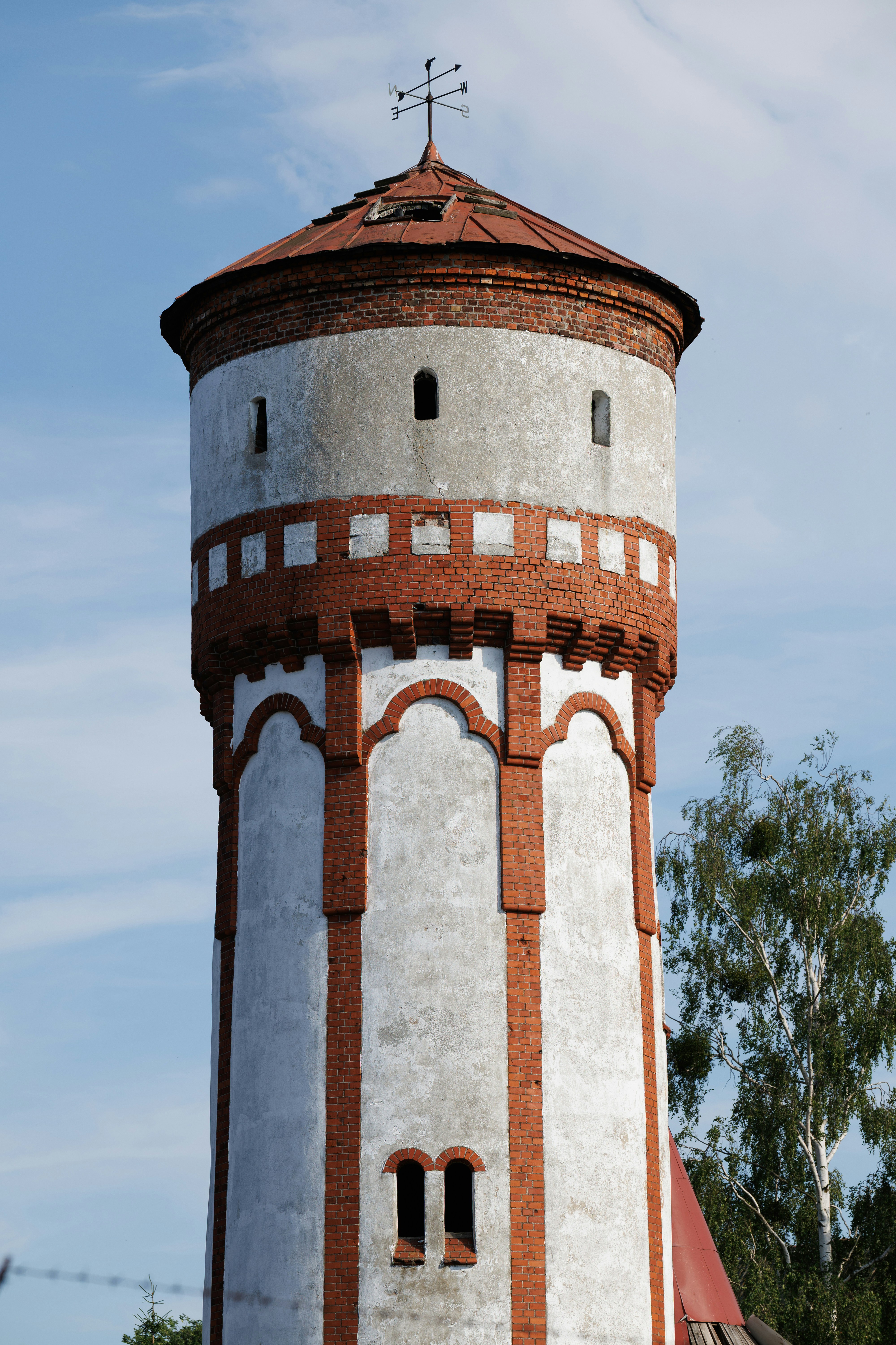 Red Brick Tower with White Plaster and weathered details under a clear sky