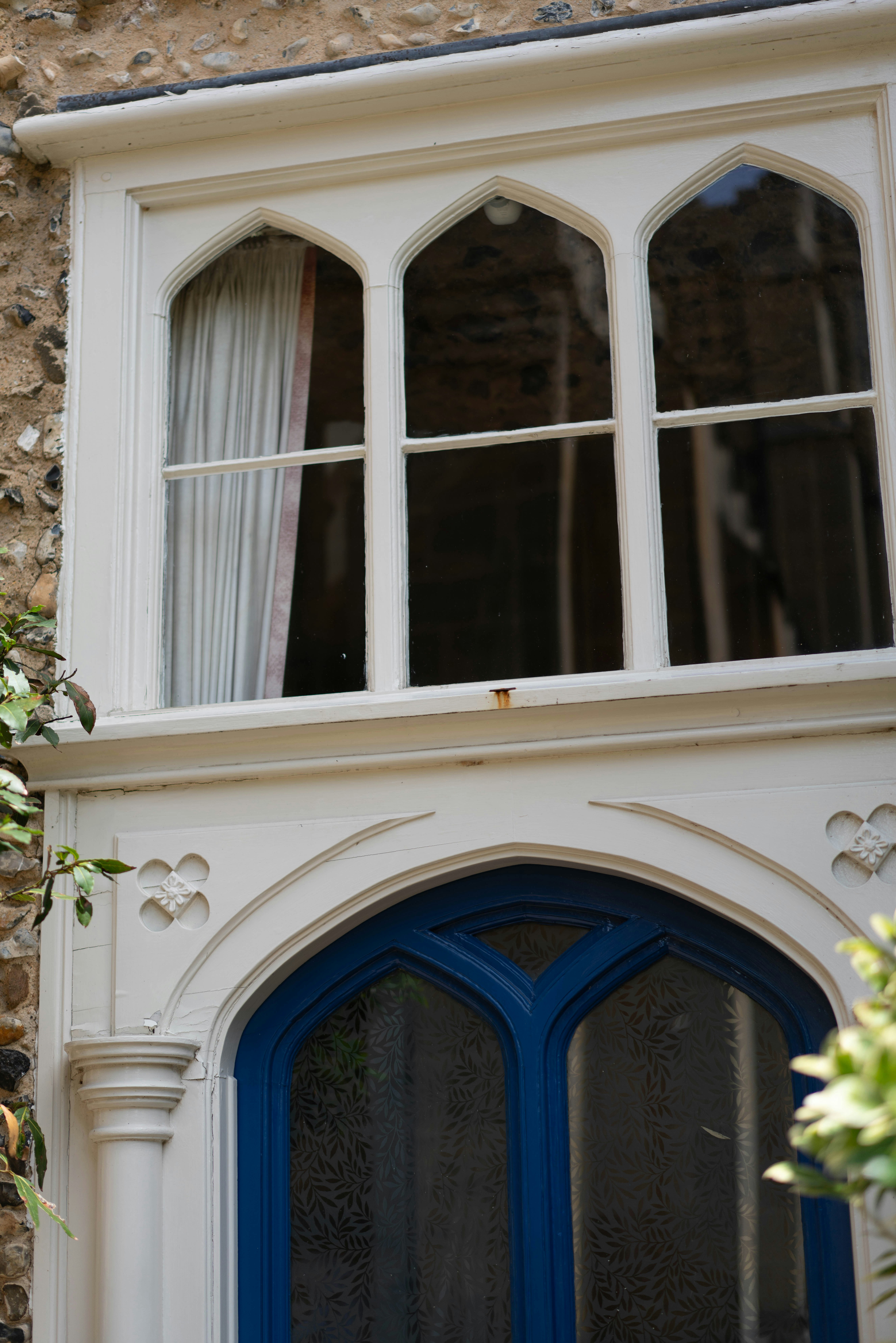 Blue-arched Doorway Framed by White Gothic Window