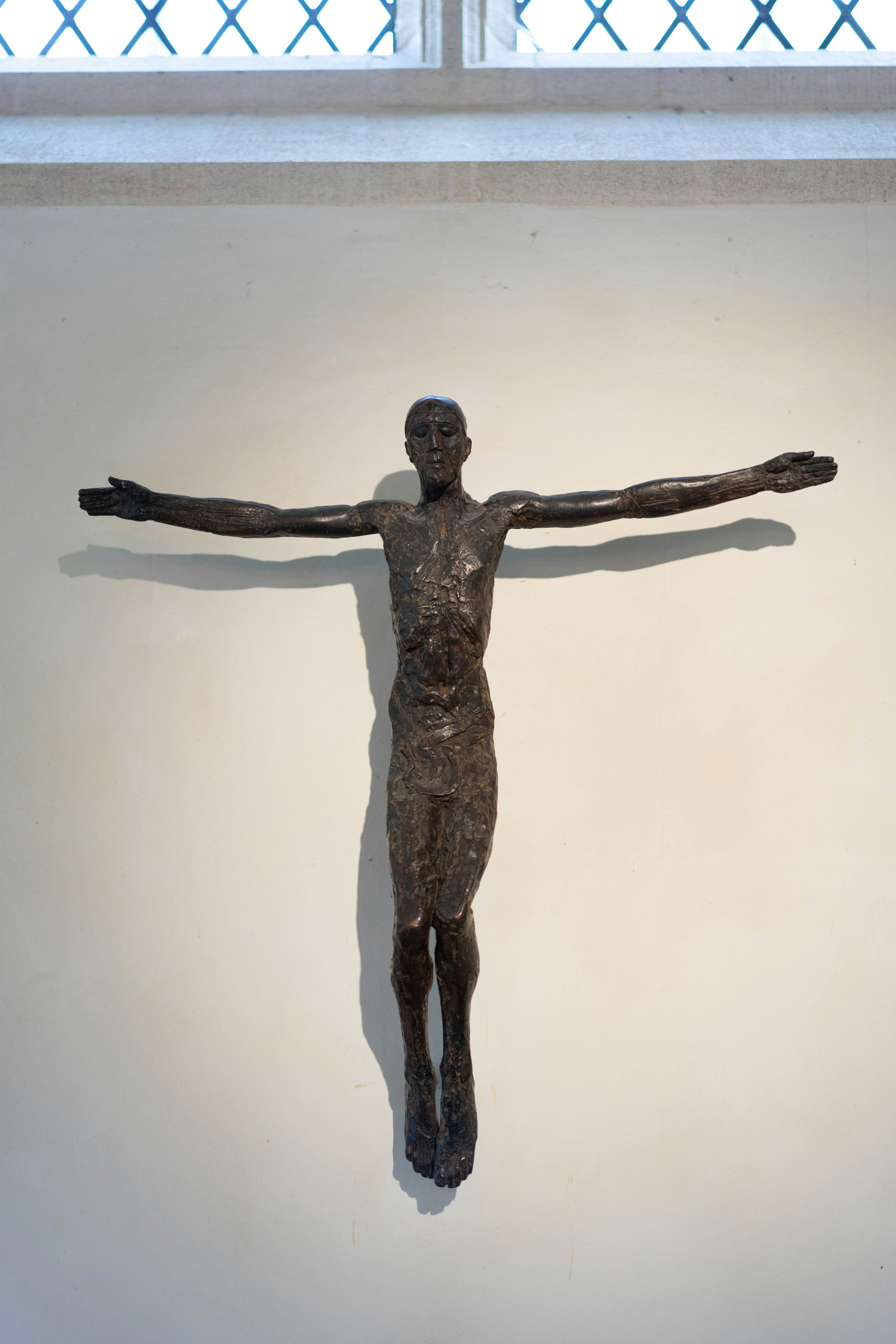 Concrete Silence: A Bronze Crucifix Framed by Soft Studio Light