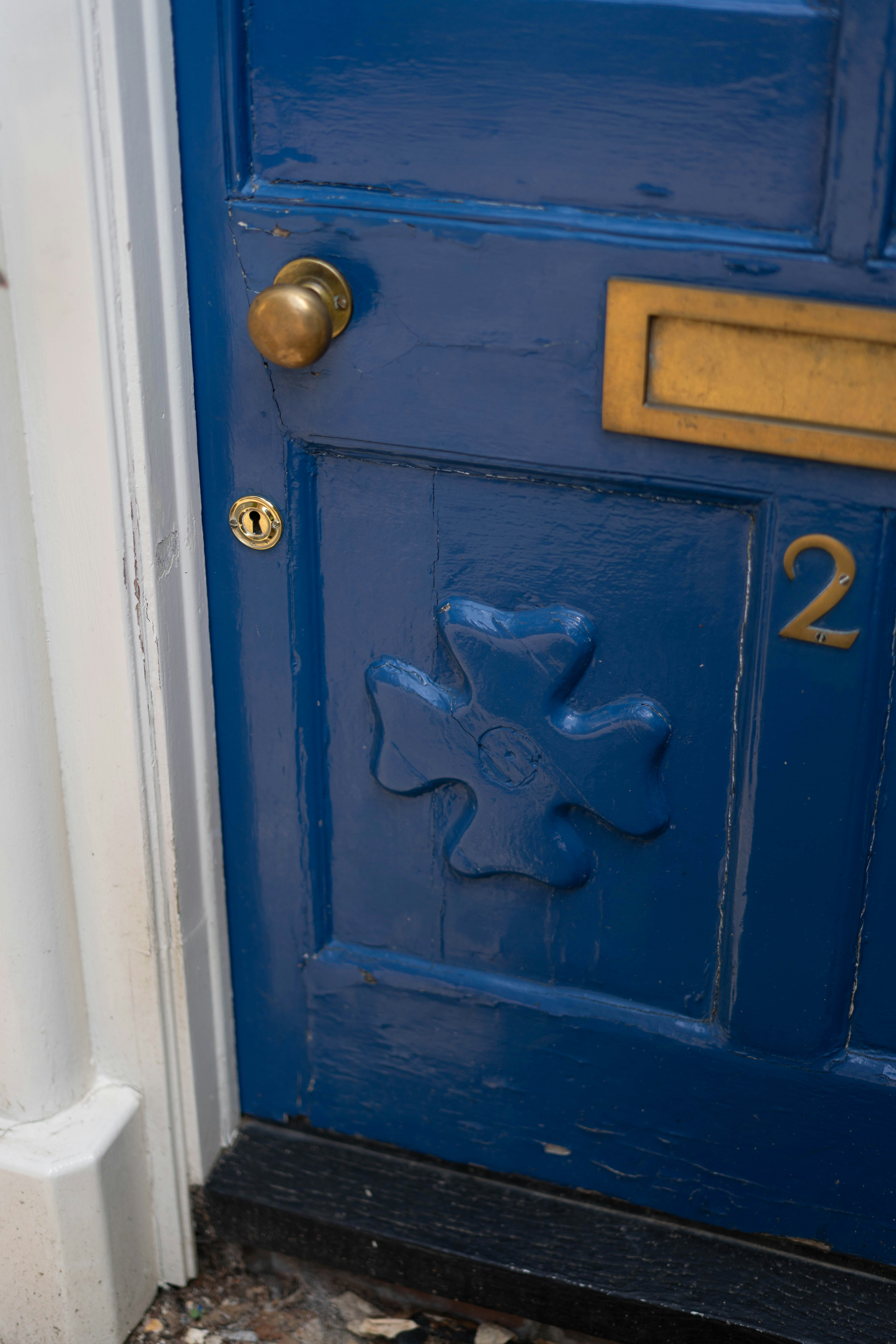 Blue Door with Brass Knob and Ornate Shield Ornament
