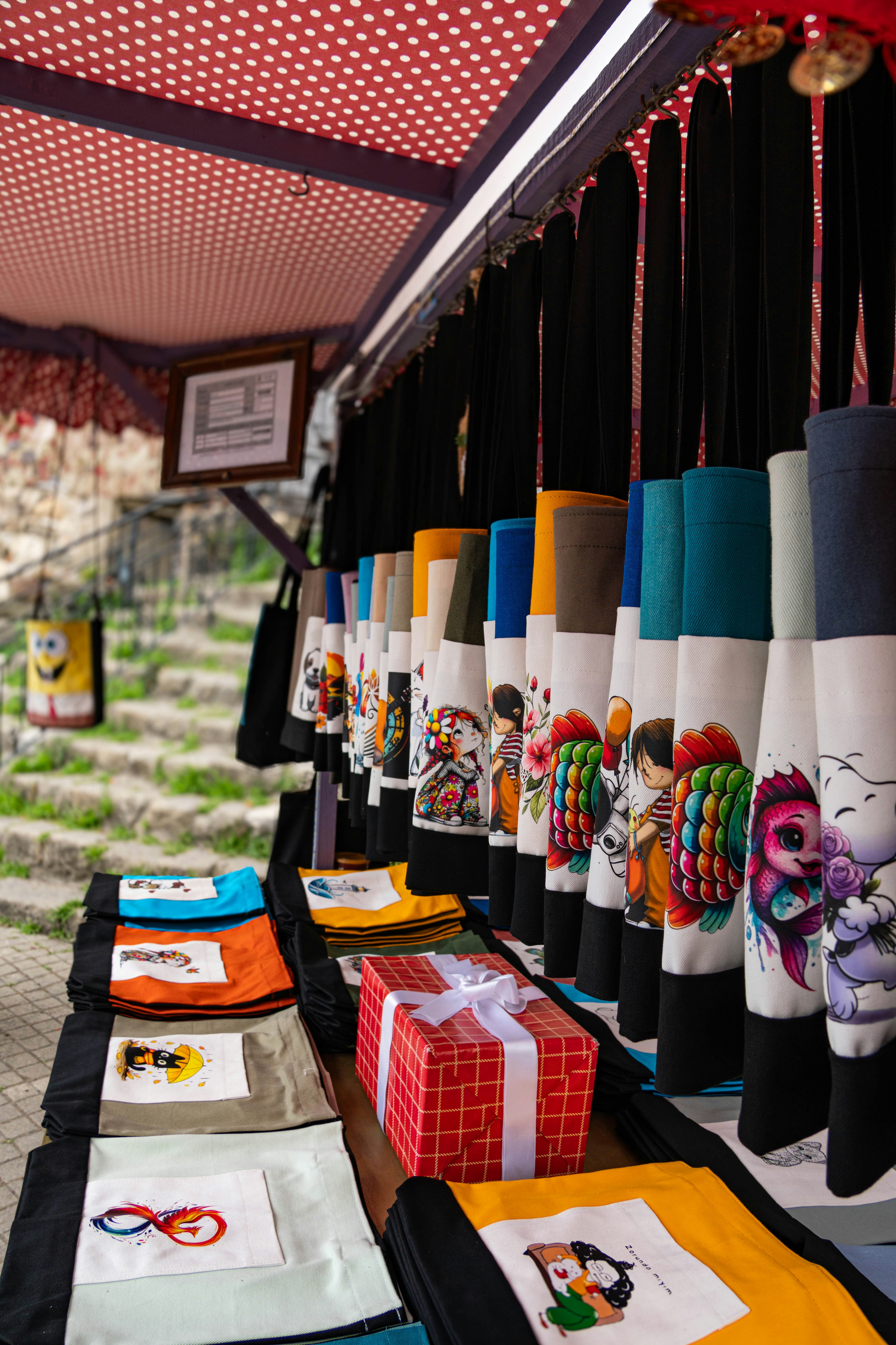 Colorful Garments on Display: A Row of Embroidered Sleeves Under a Red Dotted Canopy