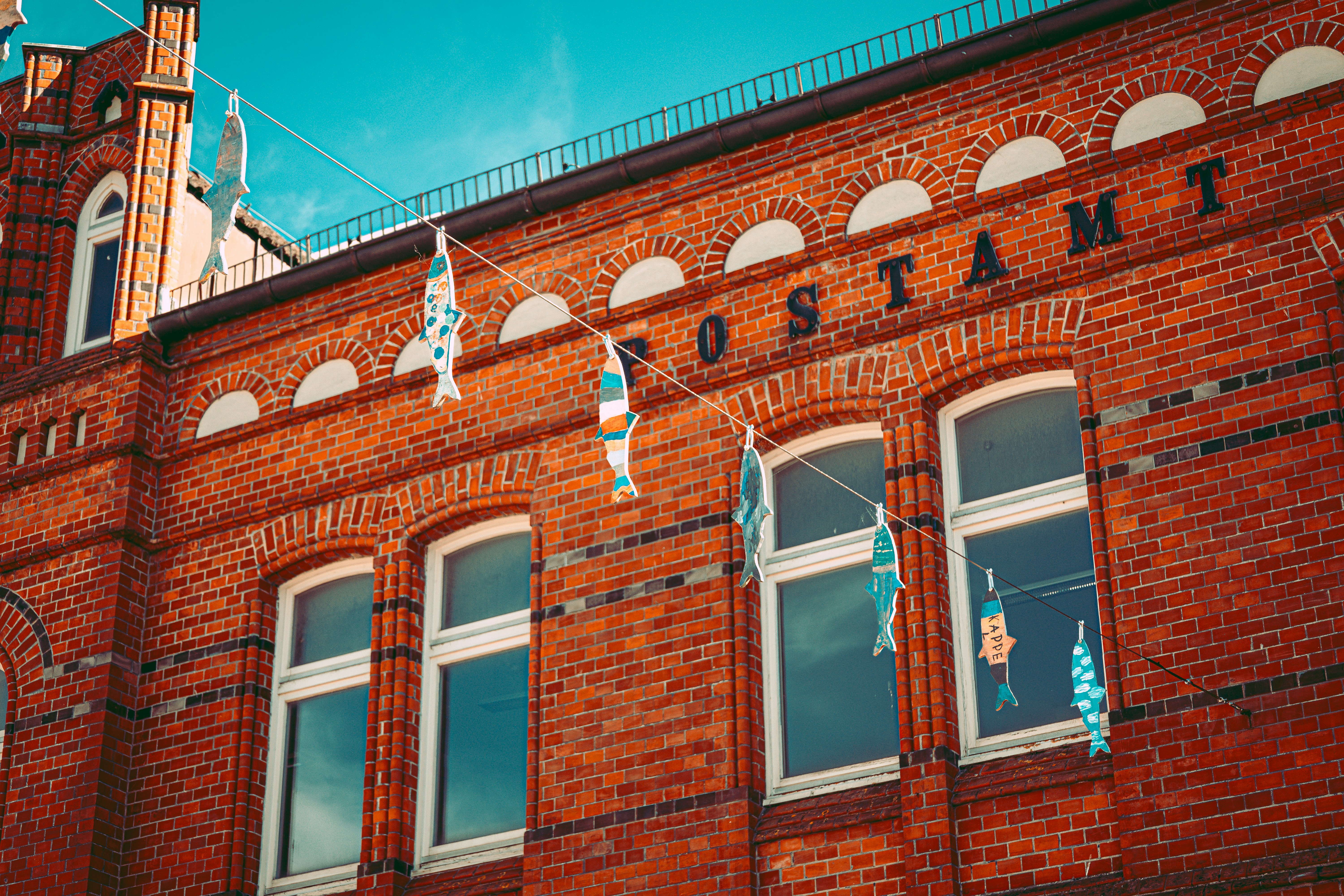 Brick Facade with Diagonal Flags Over a Historic Station