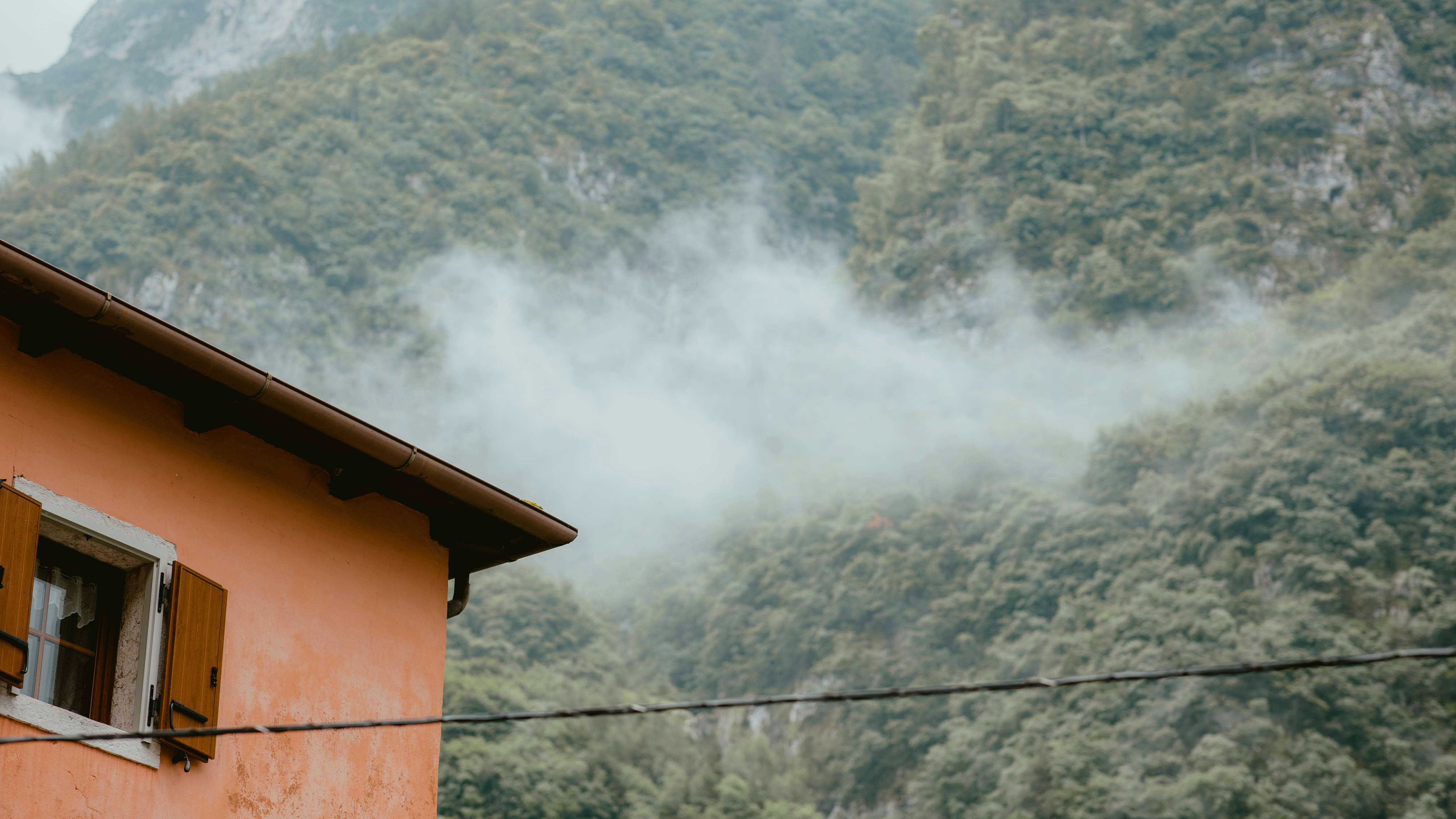 Terracotta Roof and Mist over Alpine Terrain