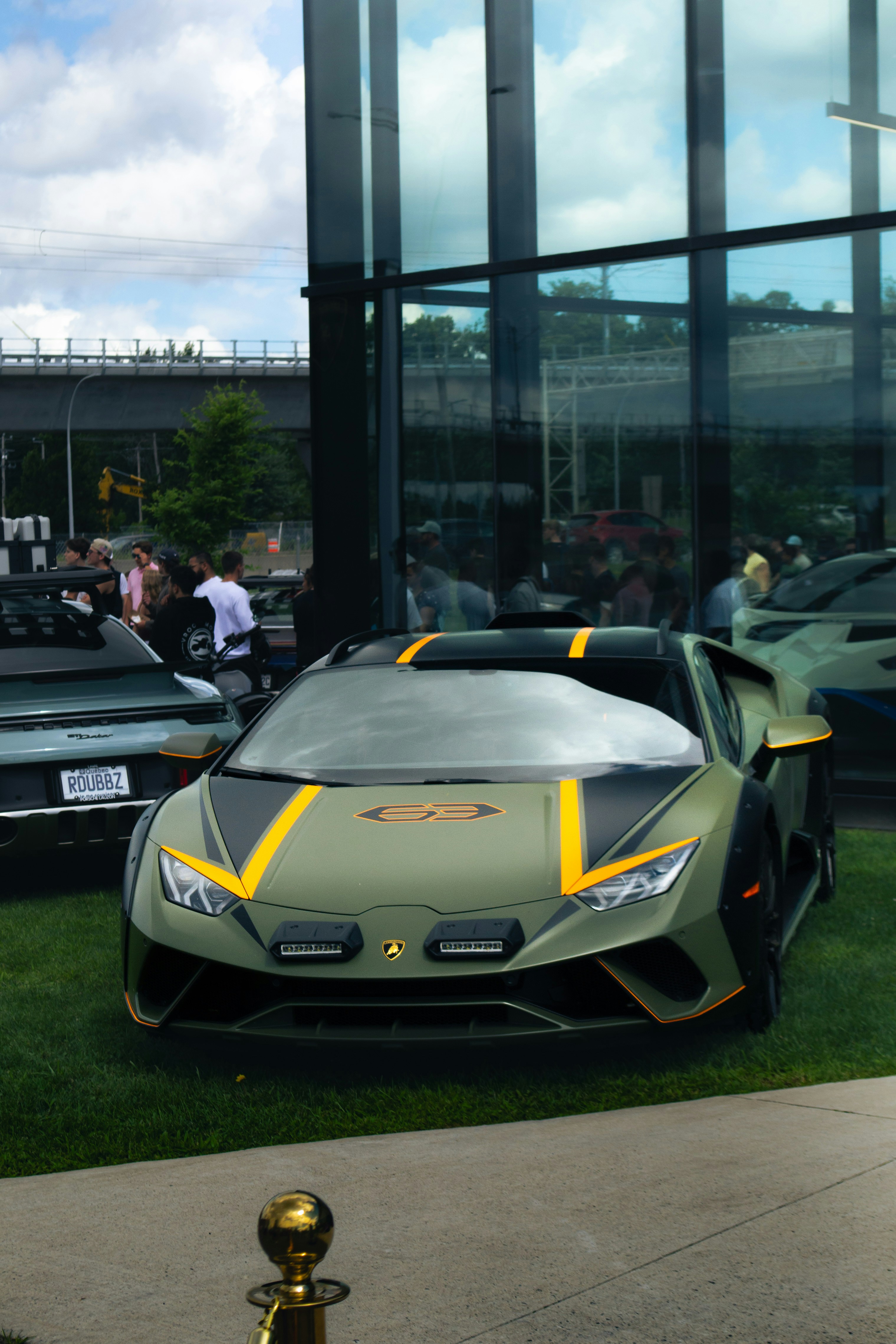Green Lamborghini Huracan with Yellow Racing Stripes at an Auto Show
