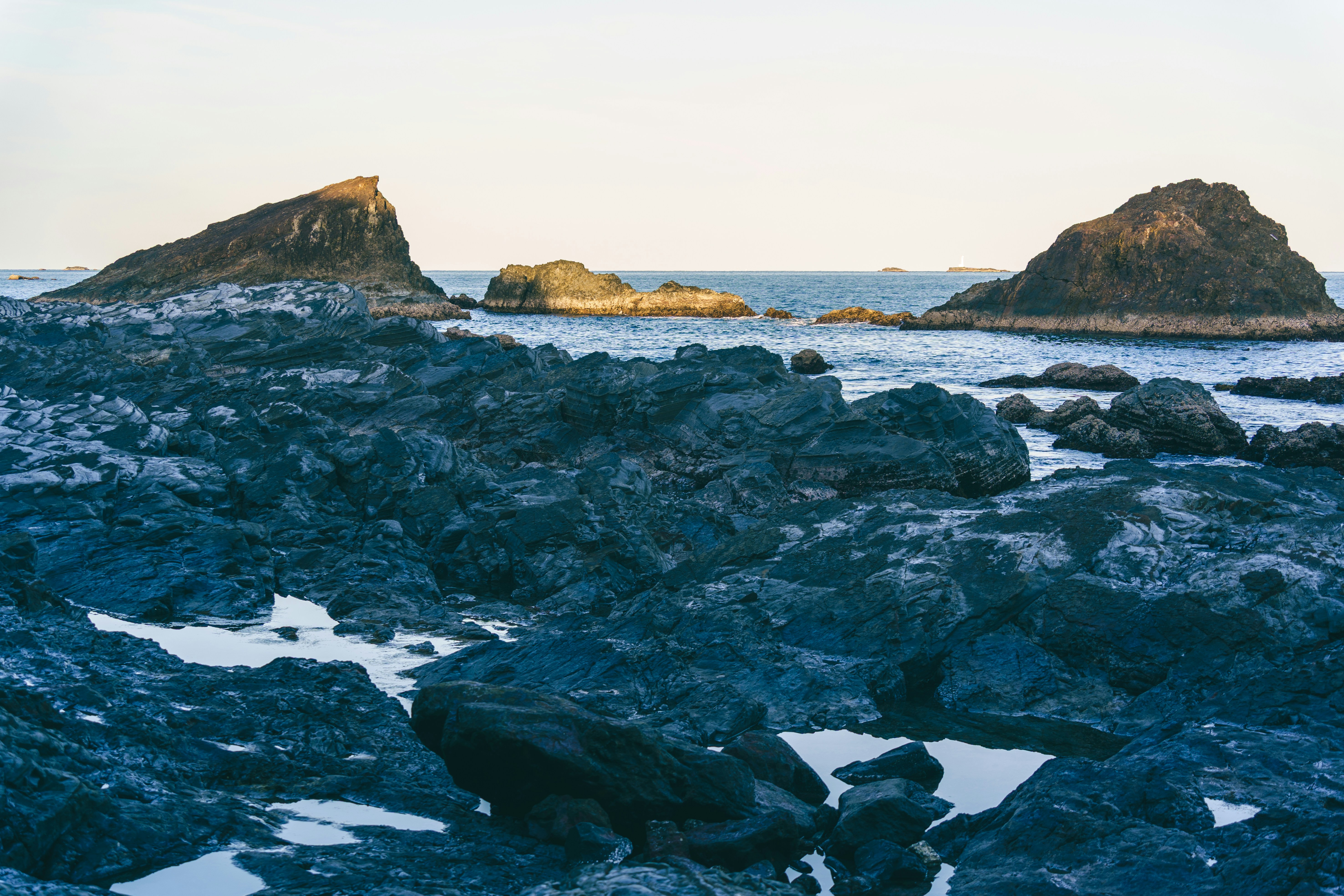 Coastal Sentinel: Sunlit Islets Rising from Tidal Rock