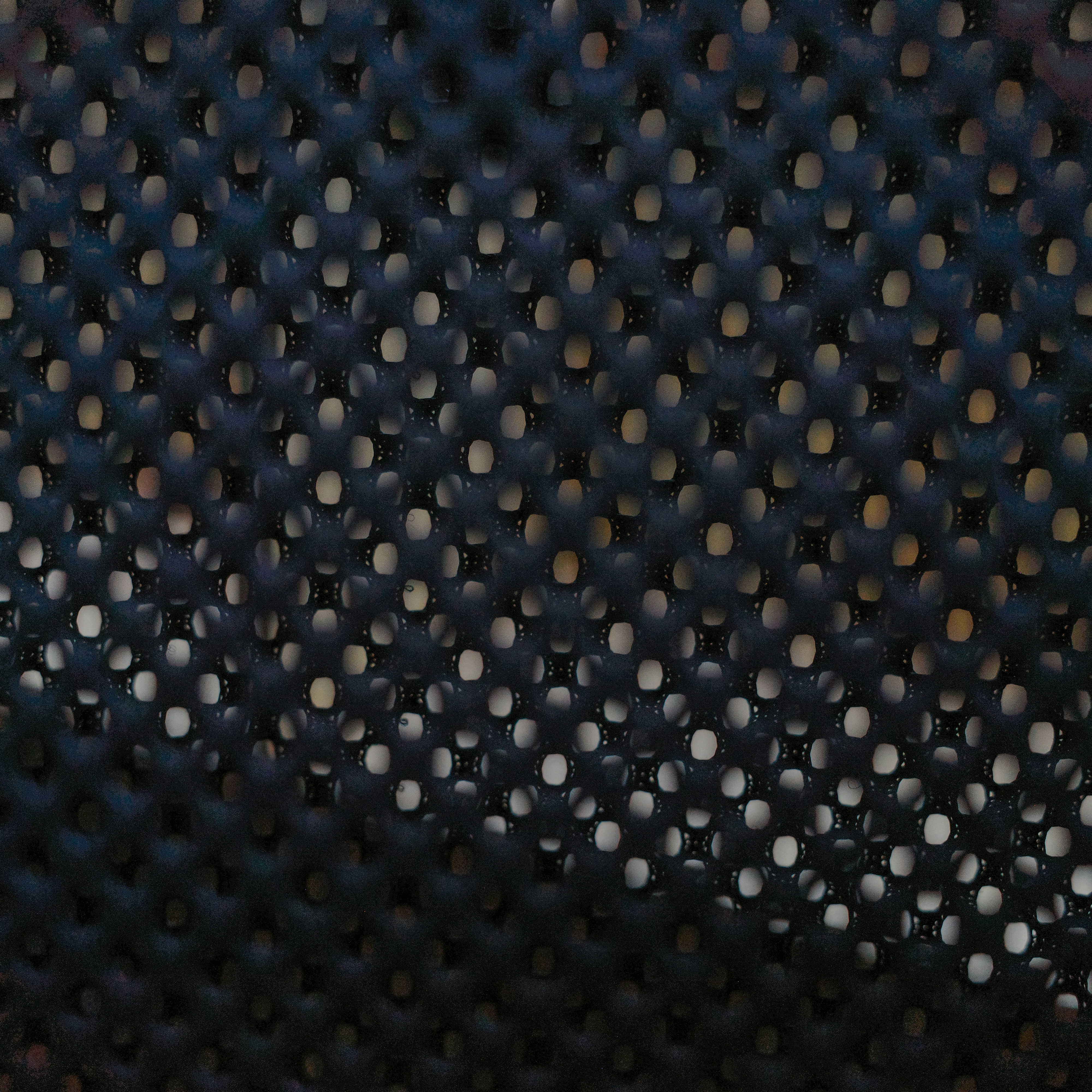 Patterned Darkness: Close‑up of a Textured Mesh