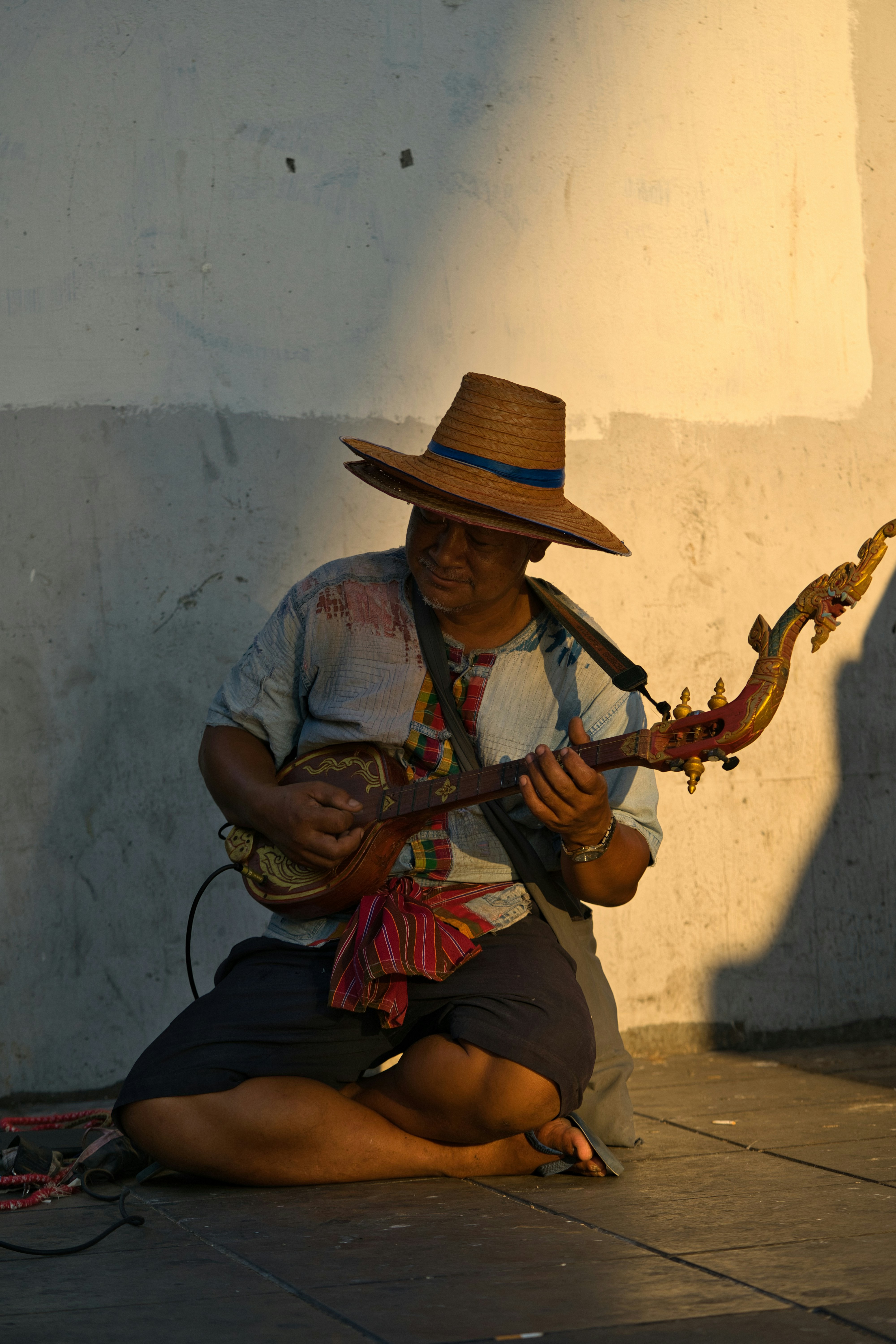 Strummed Shadows: A Street Musiker Beneath Warm Canvas-Shadowed Light