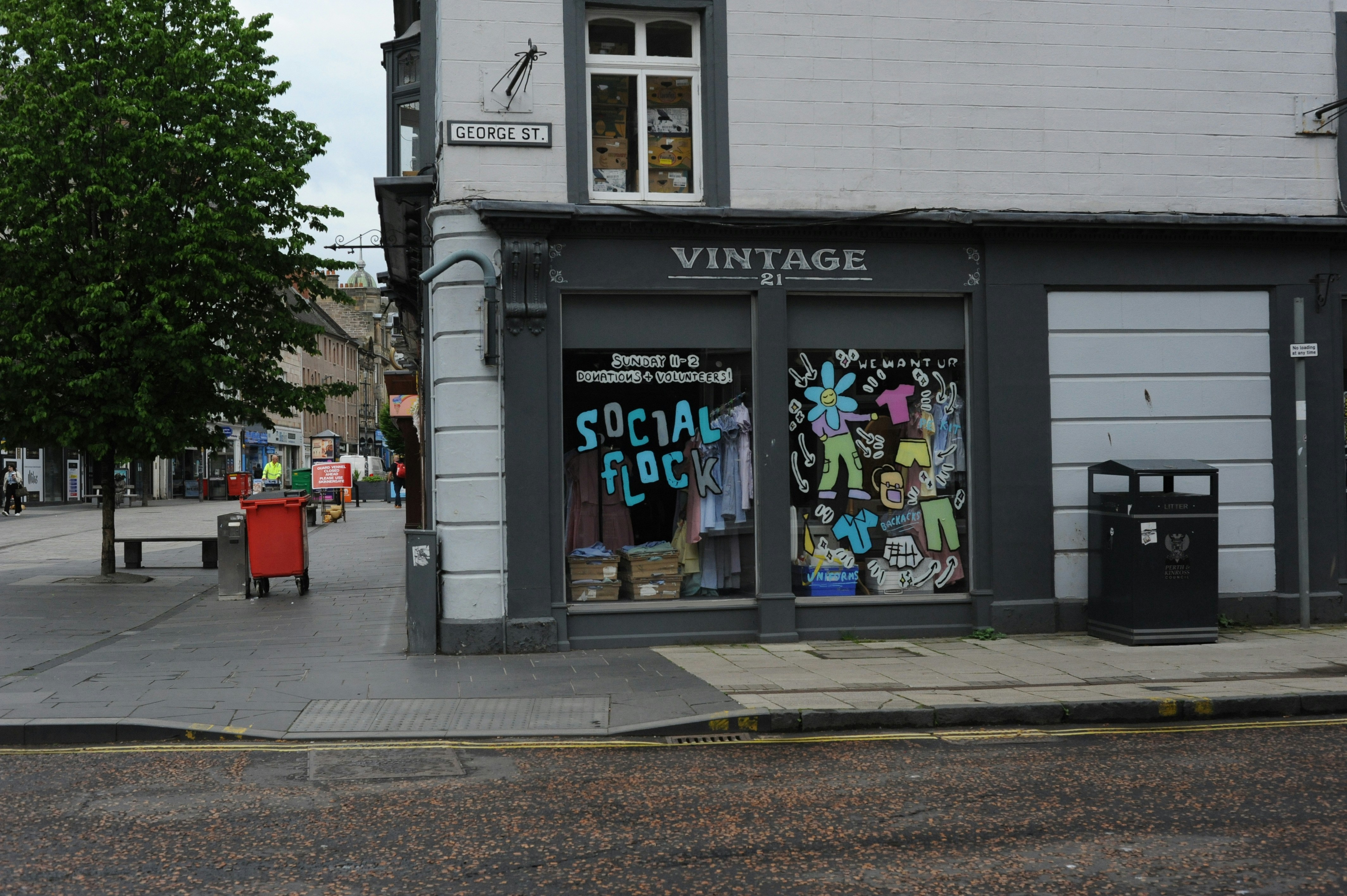 Vintage storefront with social fabric: colorful display inside a quaint shop