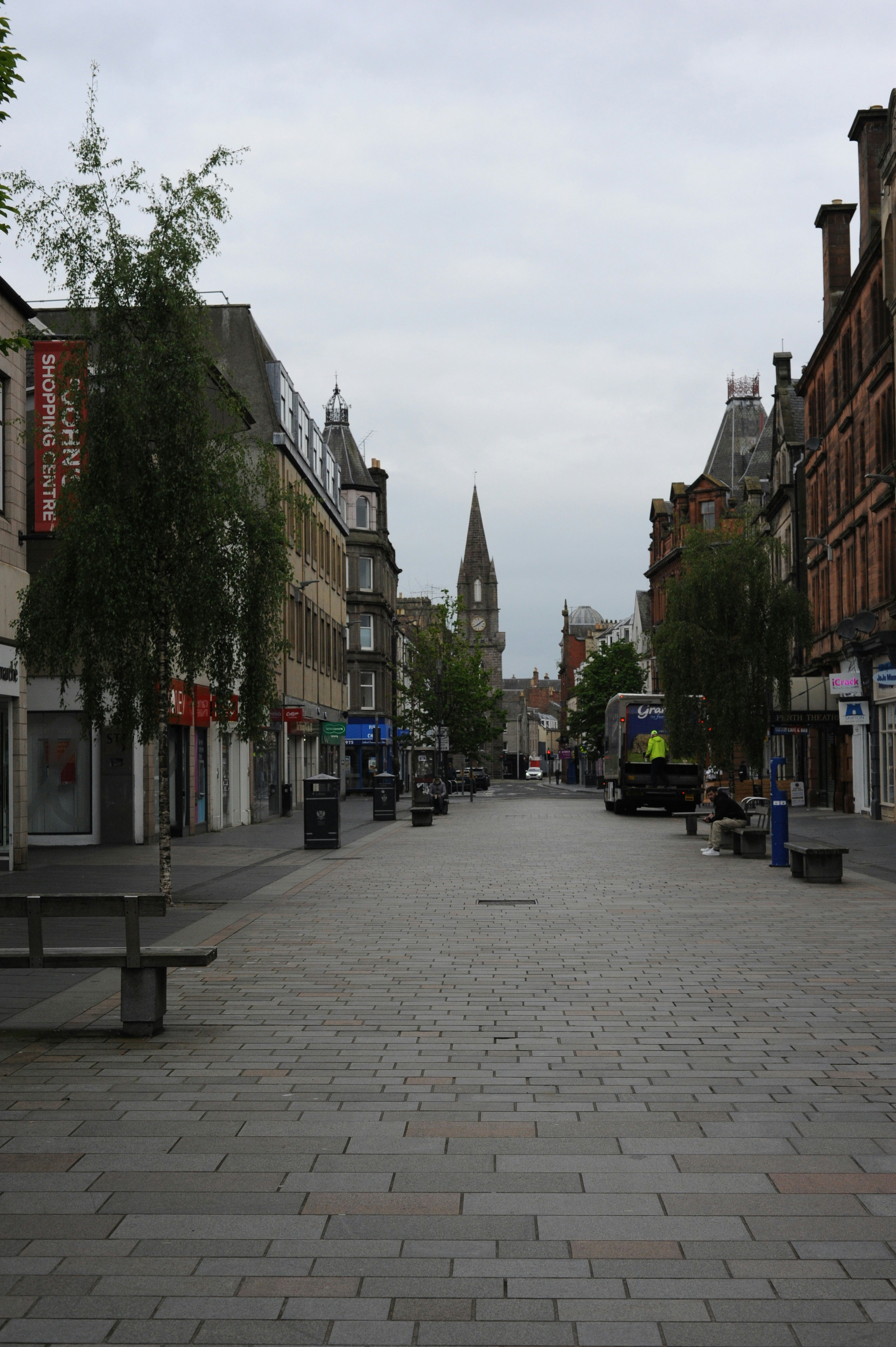 Cobbled Street Perspective: A Quiet European Main Street Leading to a Cathedral Spire