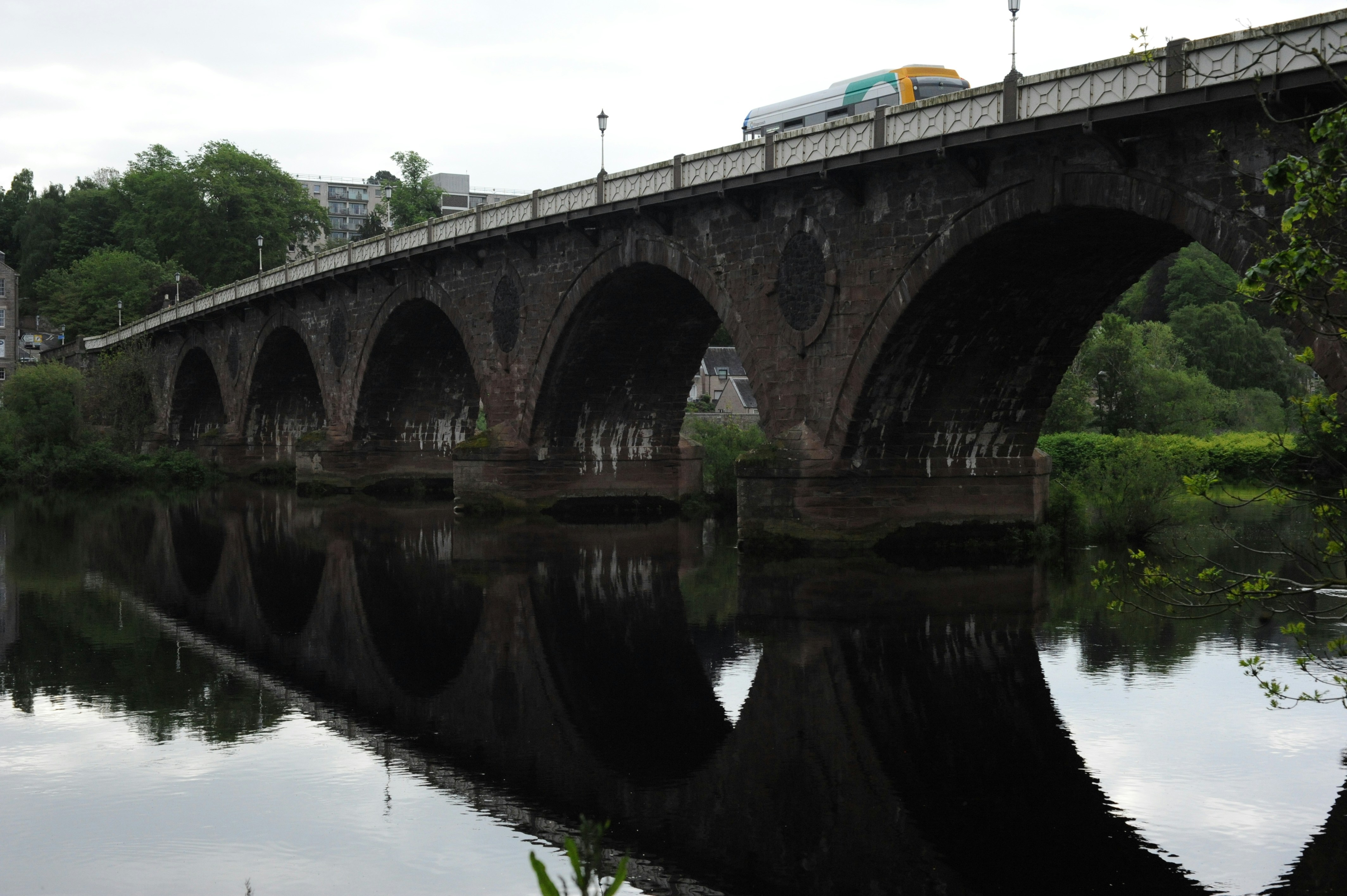 Reflected Arches: A Train Crossing the Era-Spanning Bridge