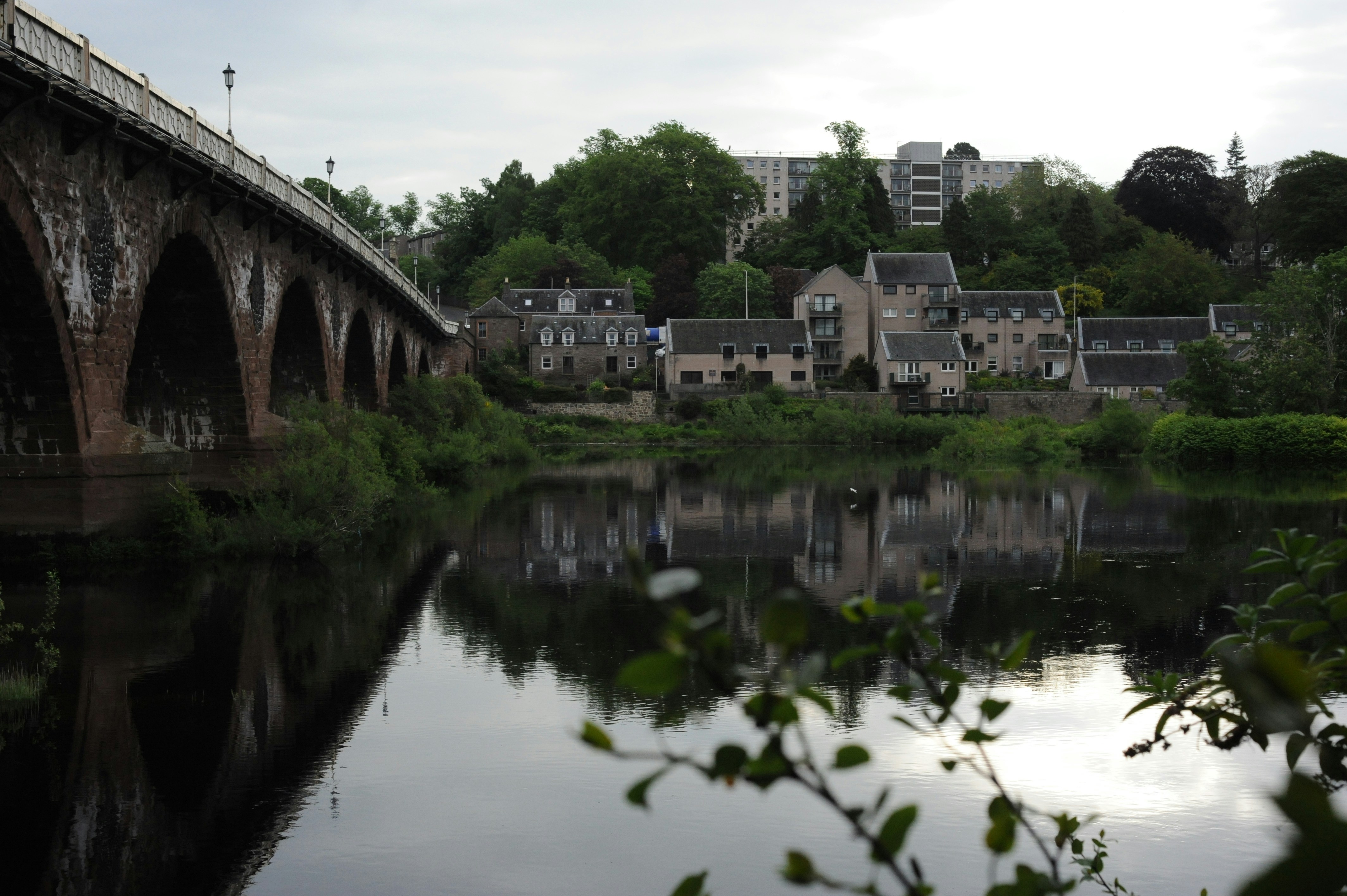 Stone Bridge Over Quiet Water: Village Grayscale in the Evening
