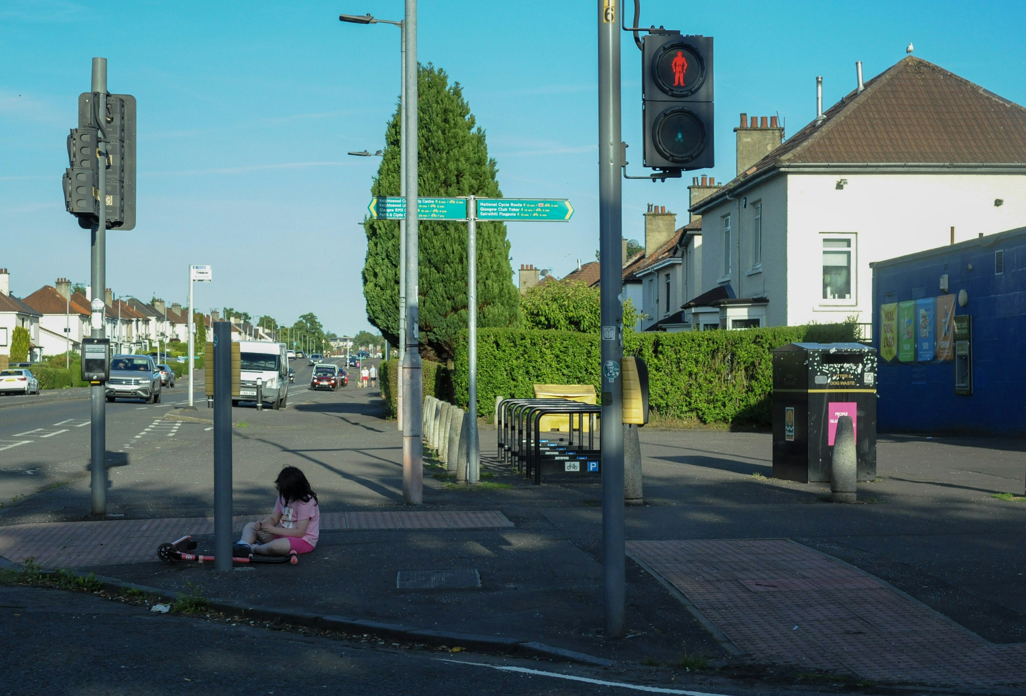 Quiet Street Corner: A Girl with a Backpack in a Sunlit UK Suburb