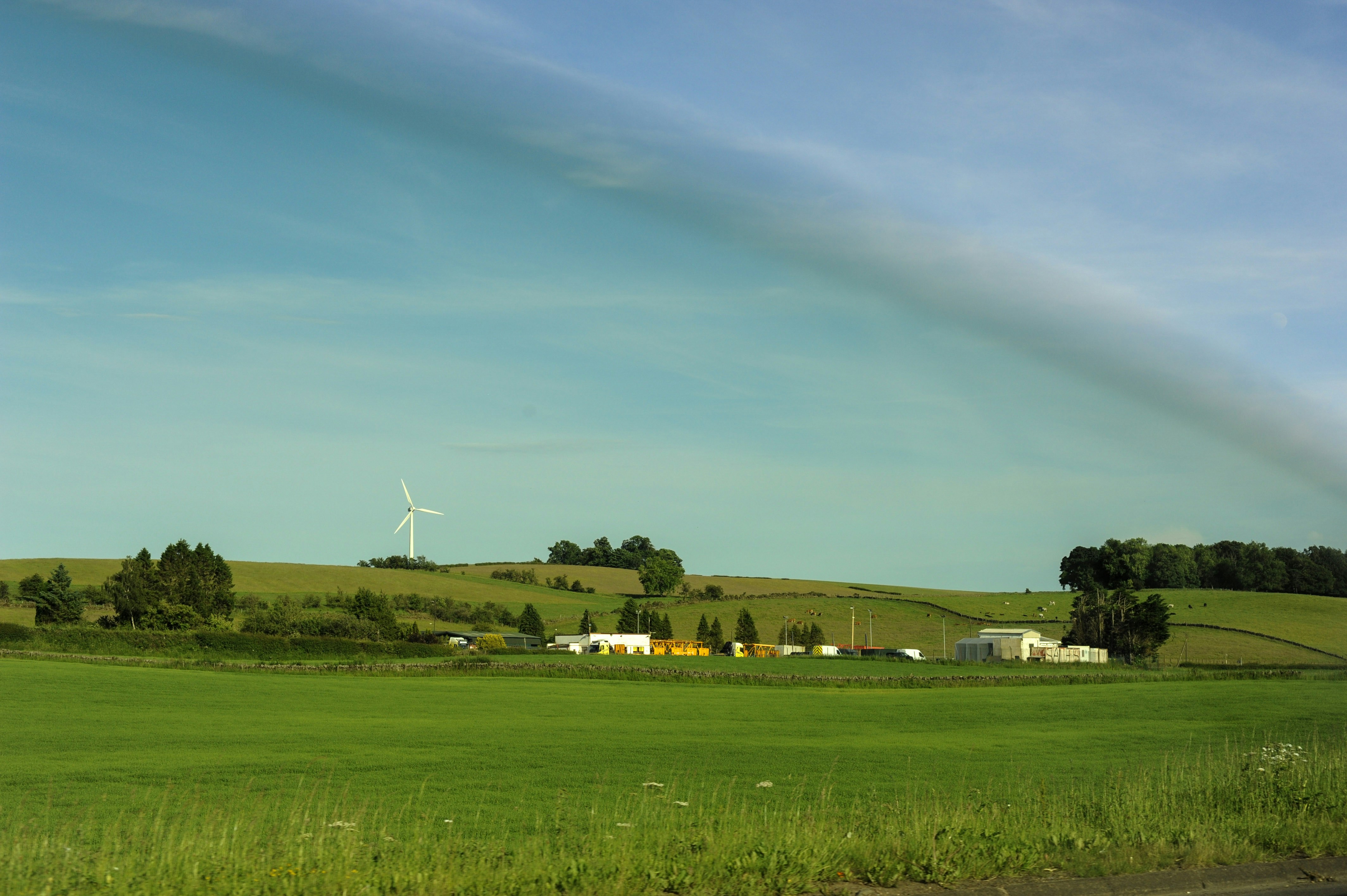Rural Horizon with Wind Turbine Under Wide Blue Sky