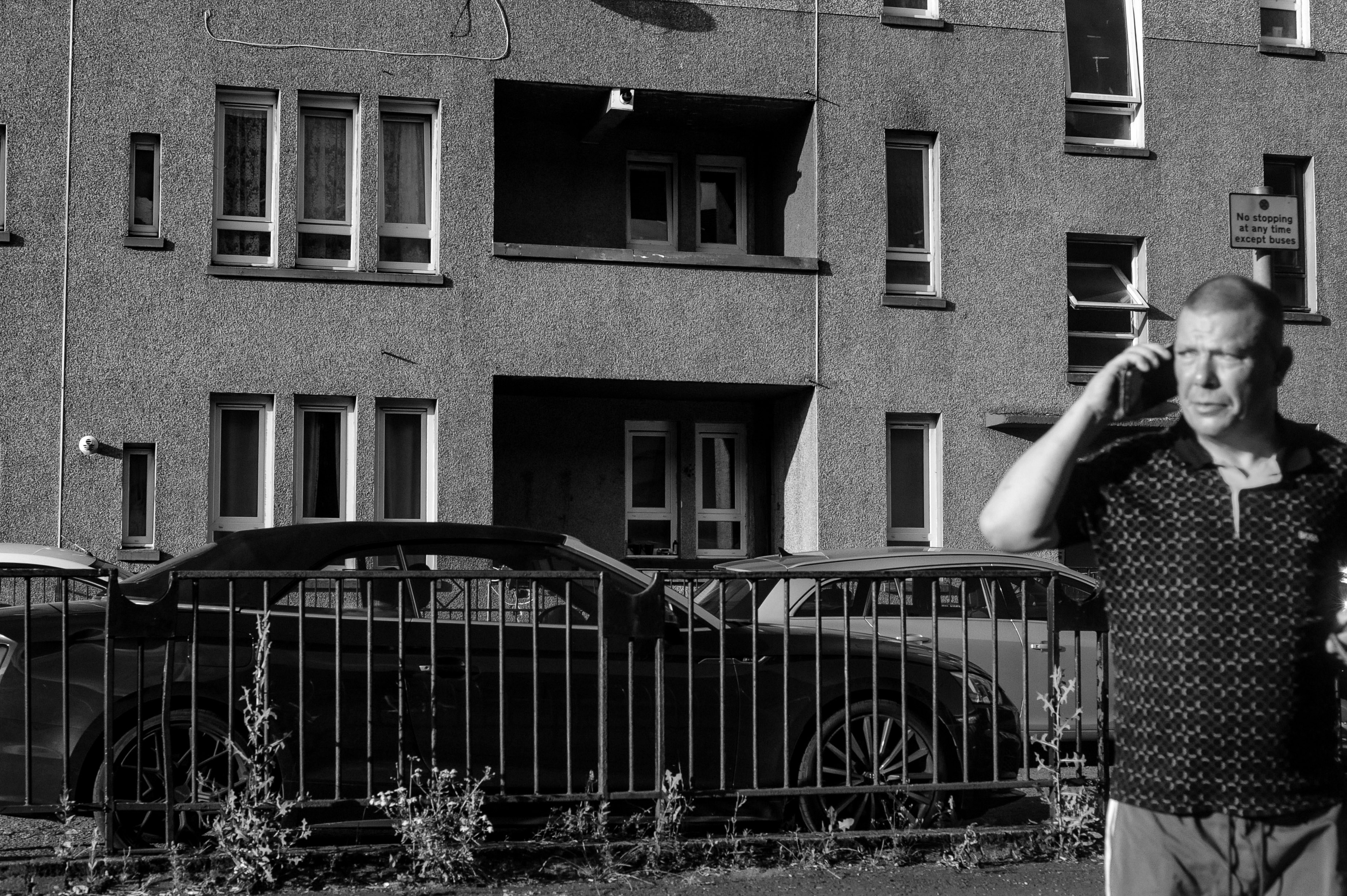 On the Line: A Man on a Call in Front of a Blocky Facade