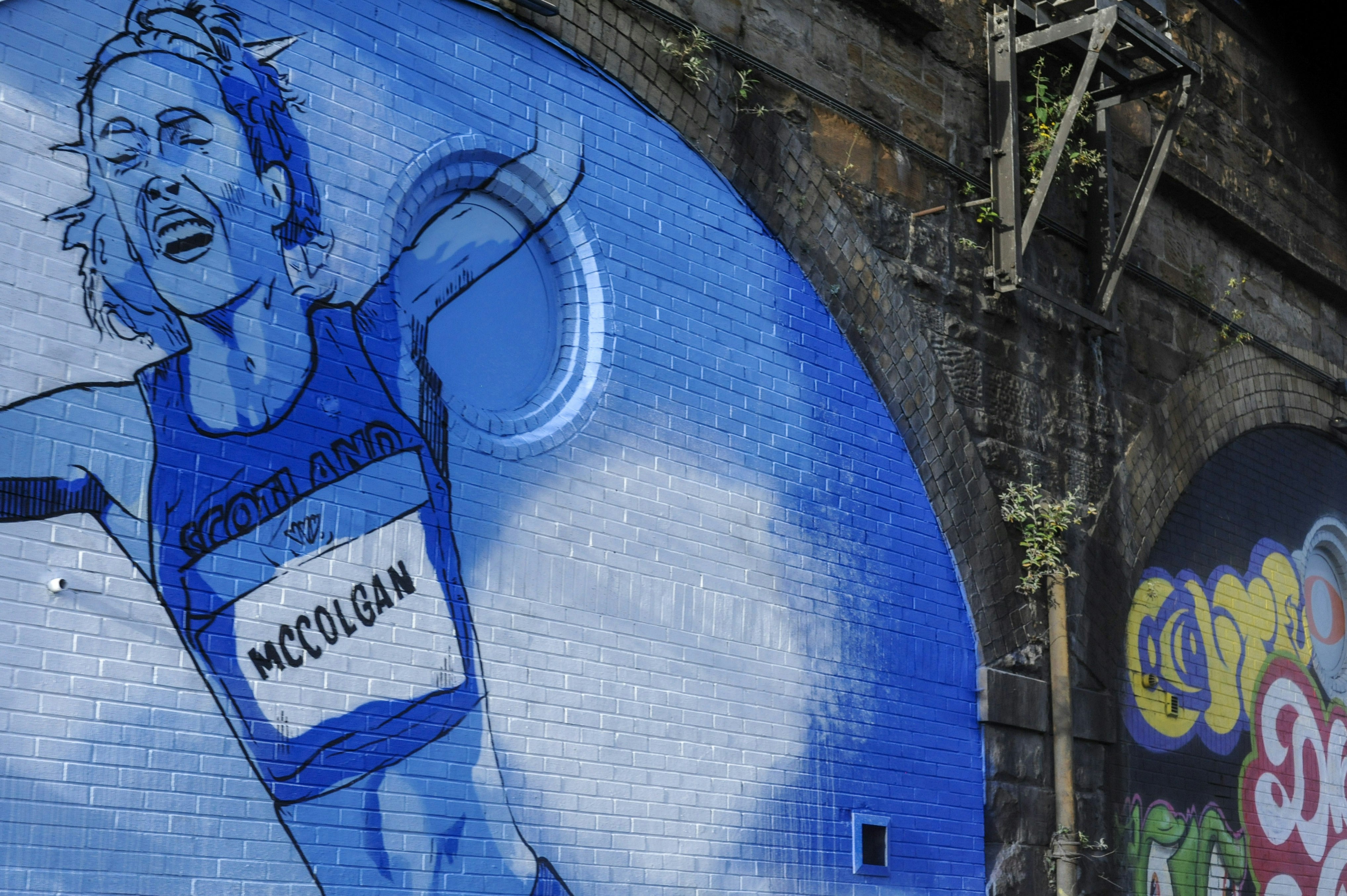 Blue Marathon: Graffiti Portrait of a Runner in an Urban Wall Scene