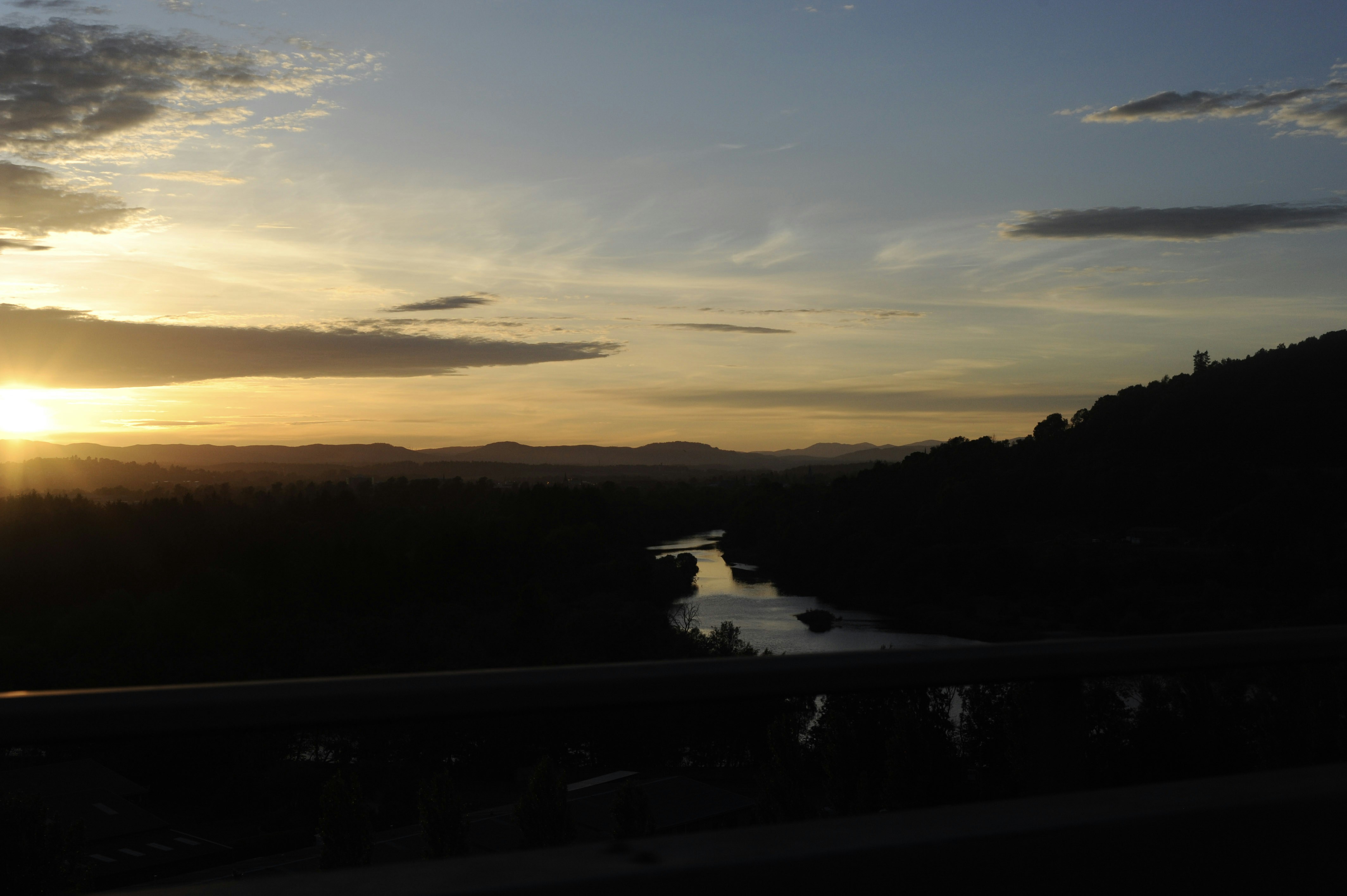 Sunset Over a Quiet River Valley from a Bridge