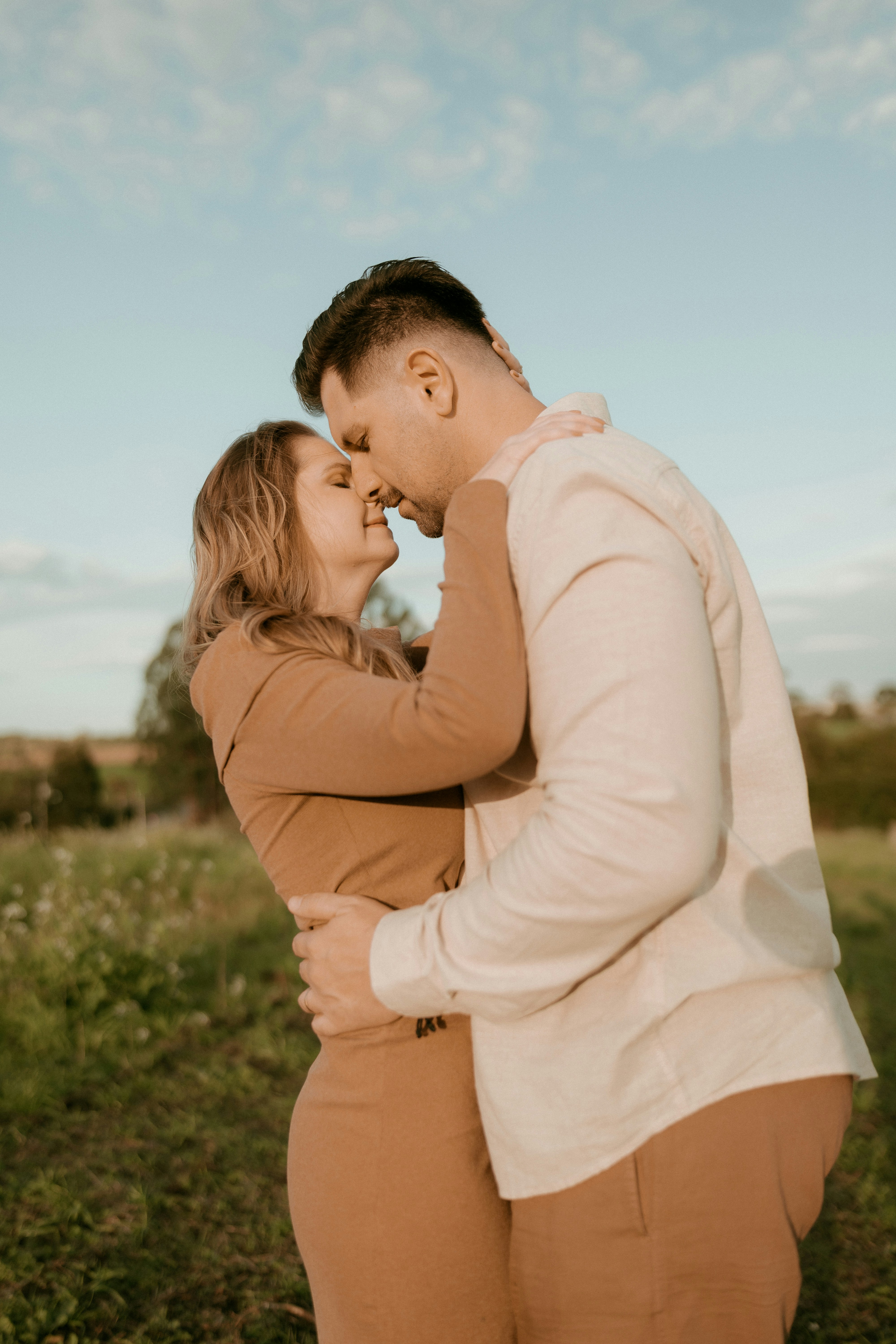 Tender embrace at golden hour in a sunlit field