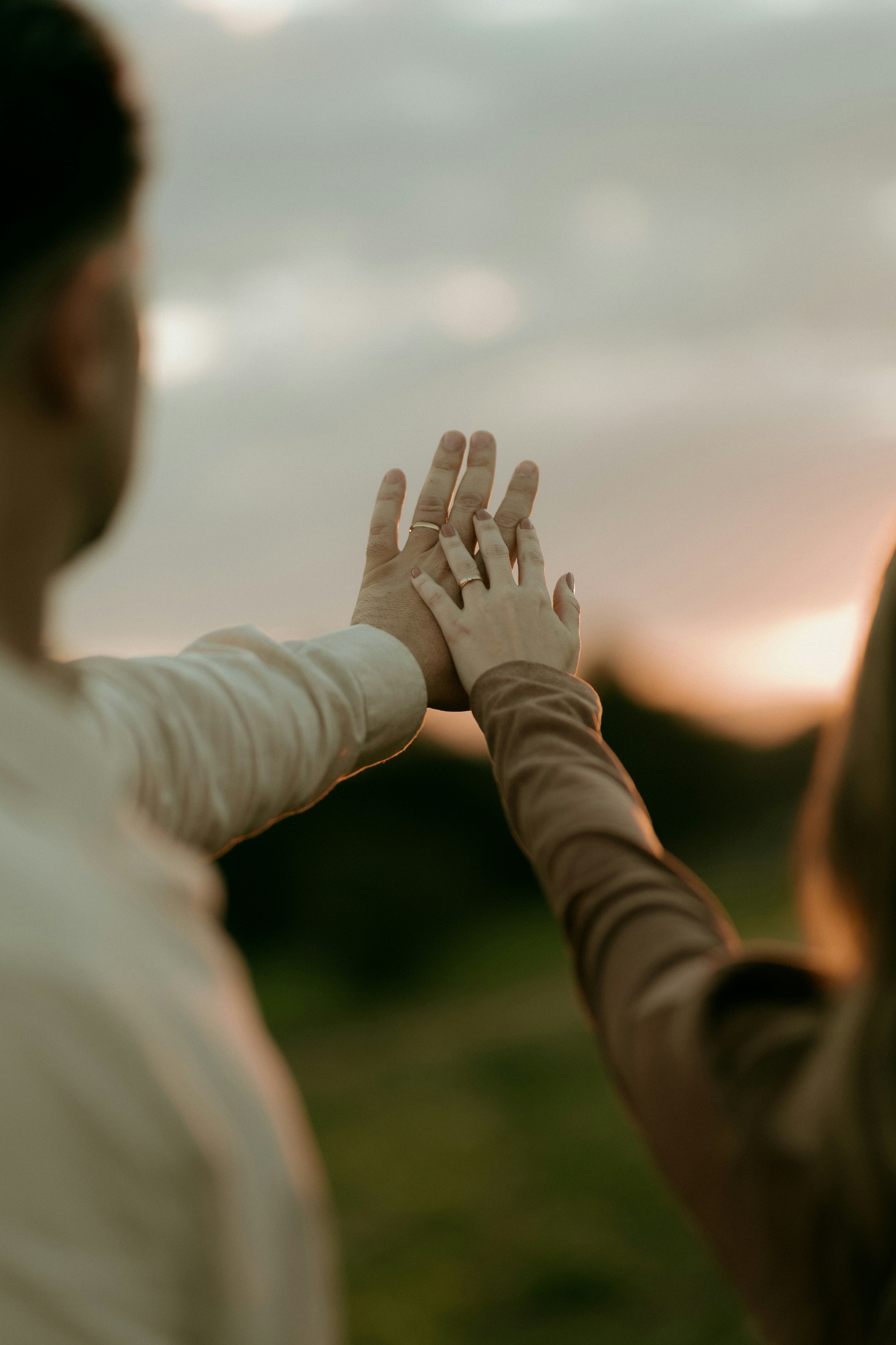 Hands Reaching for Light at Sunset