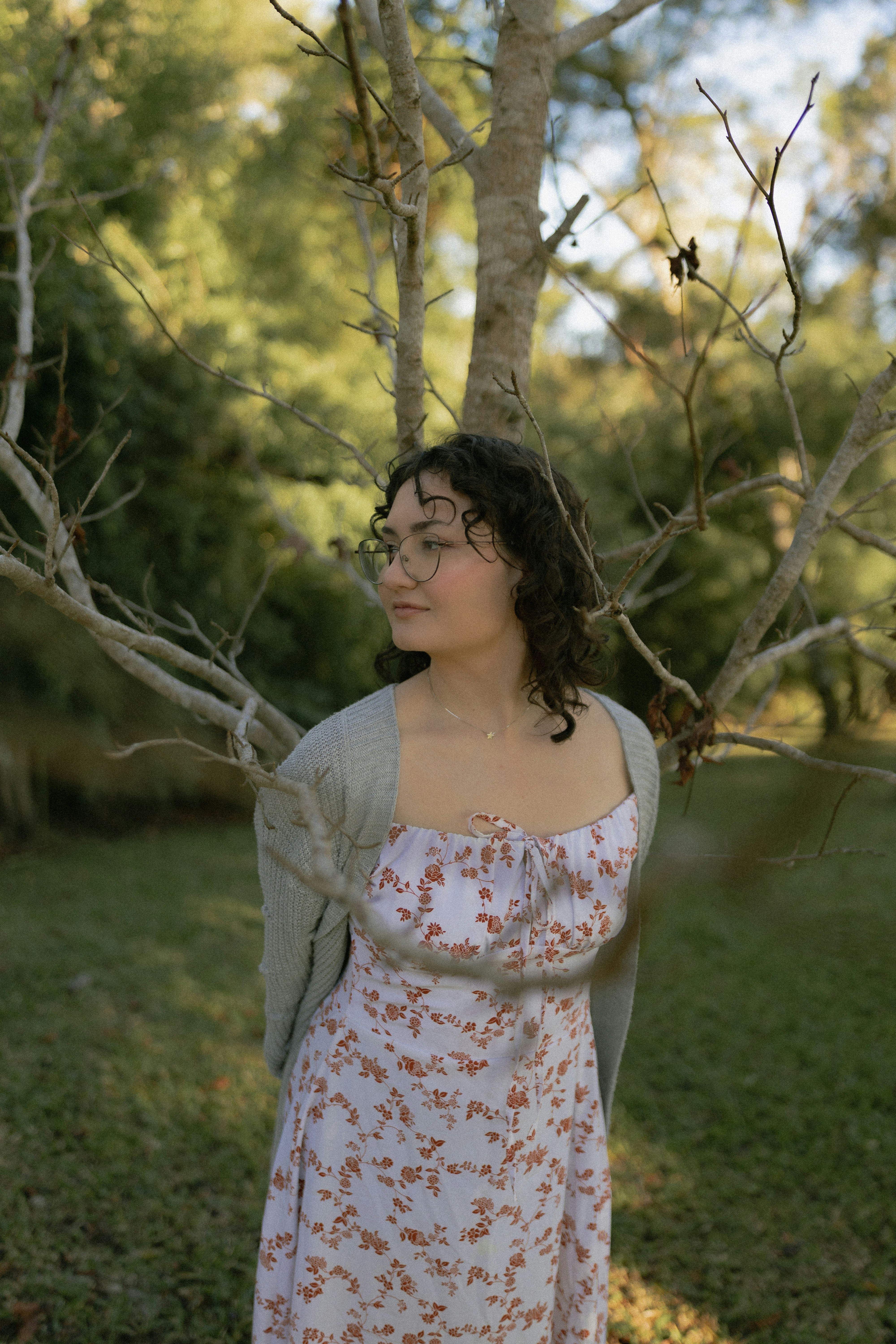 Portrait in Bloom: Soft Sunlit Moment Beneath Bare Limbs
