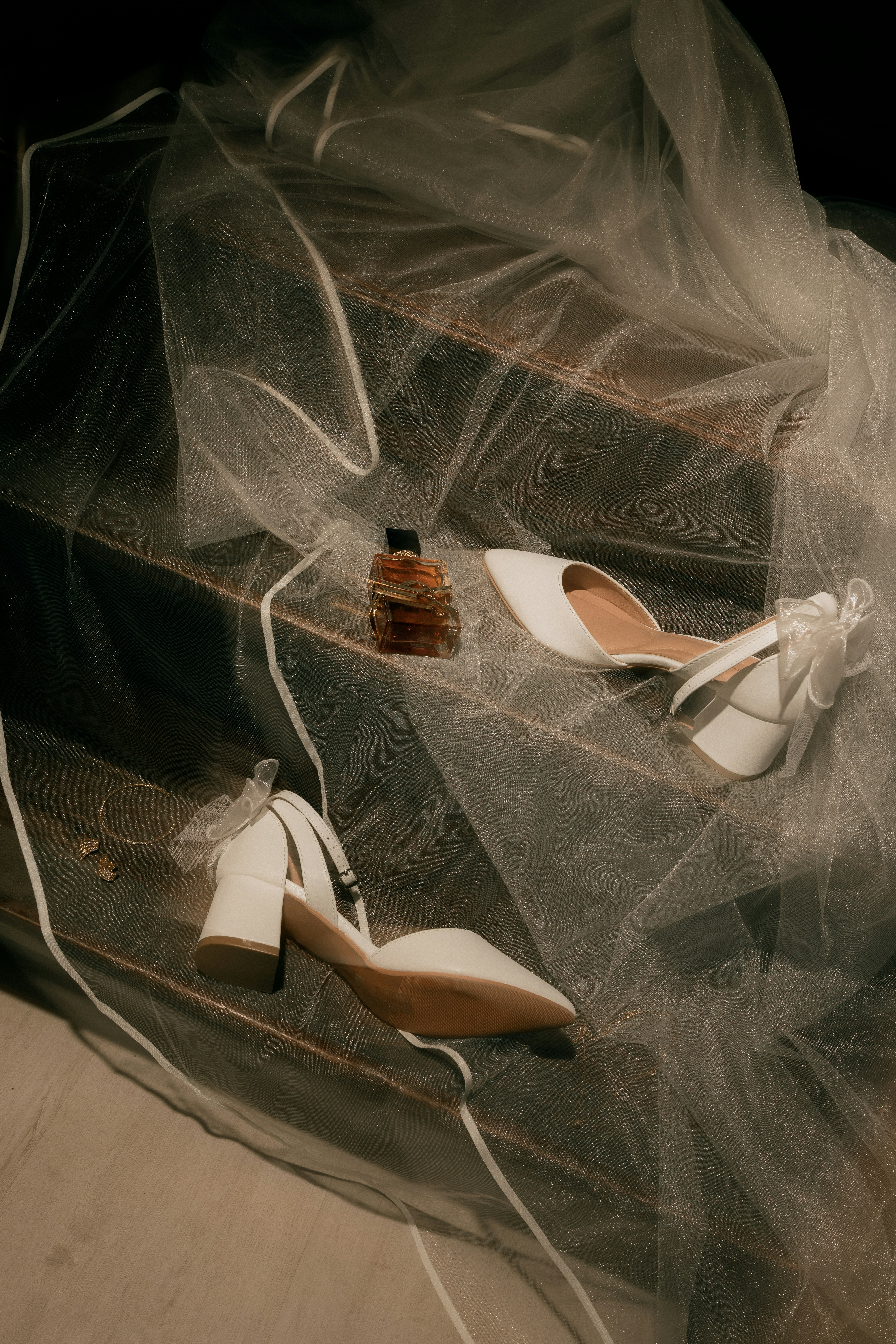 Delicate glamour in sheer layers: white heels and perfume among tulle