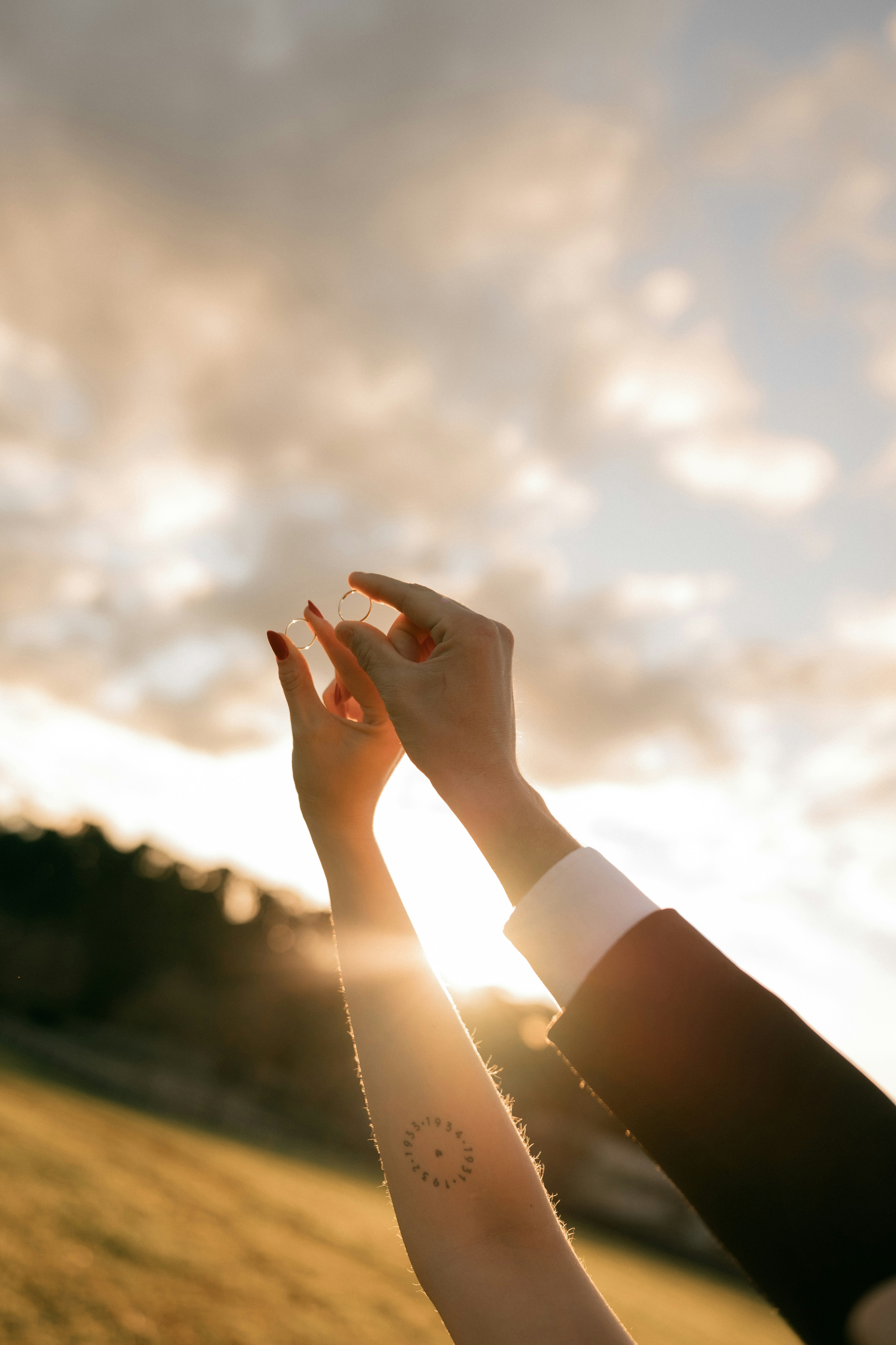Hands Reaching Toward the Sun: A Delicate Moment at Golden Hour