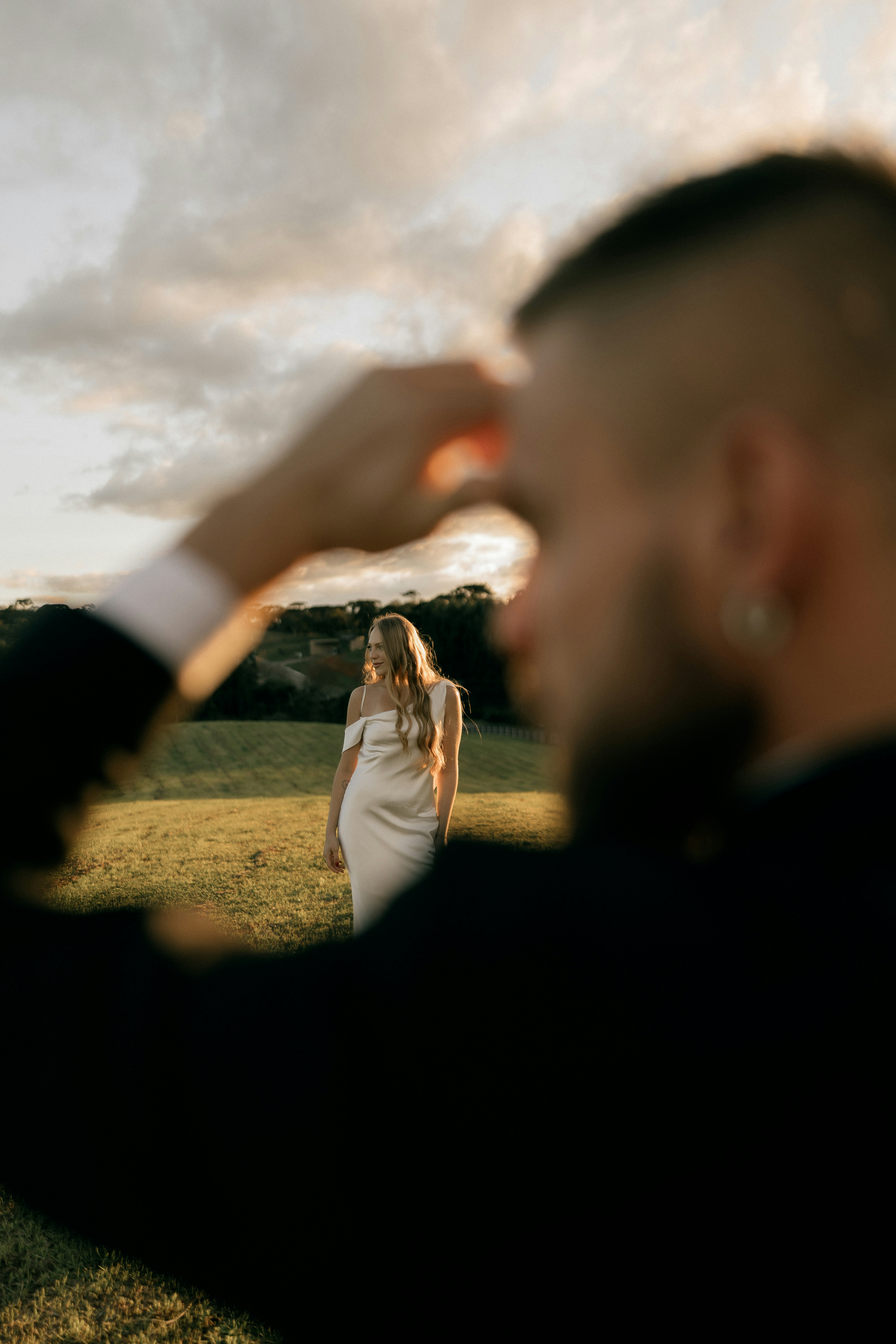 Glimmer of a Moment: The Bride in Focus with a Shy Gaze of the Groom