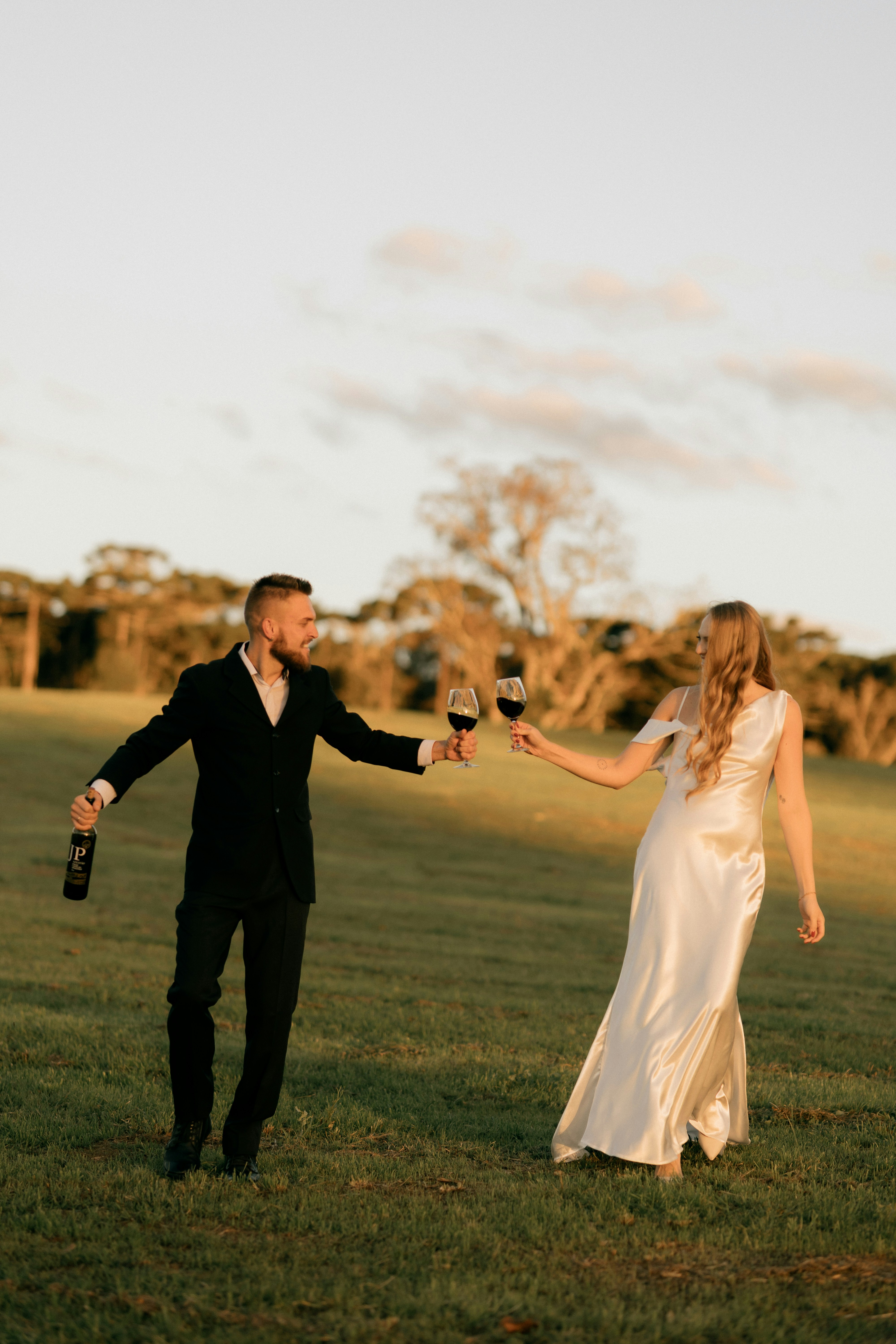 Toast Under Golden Hour: A Bride and Groom in Field