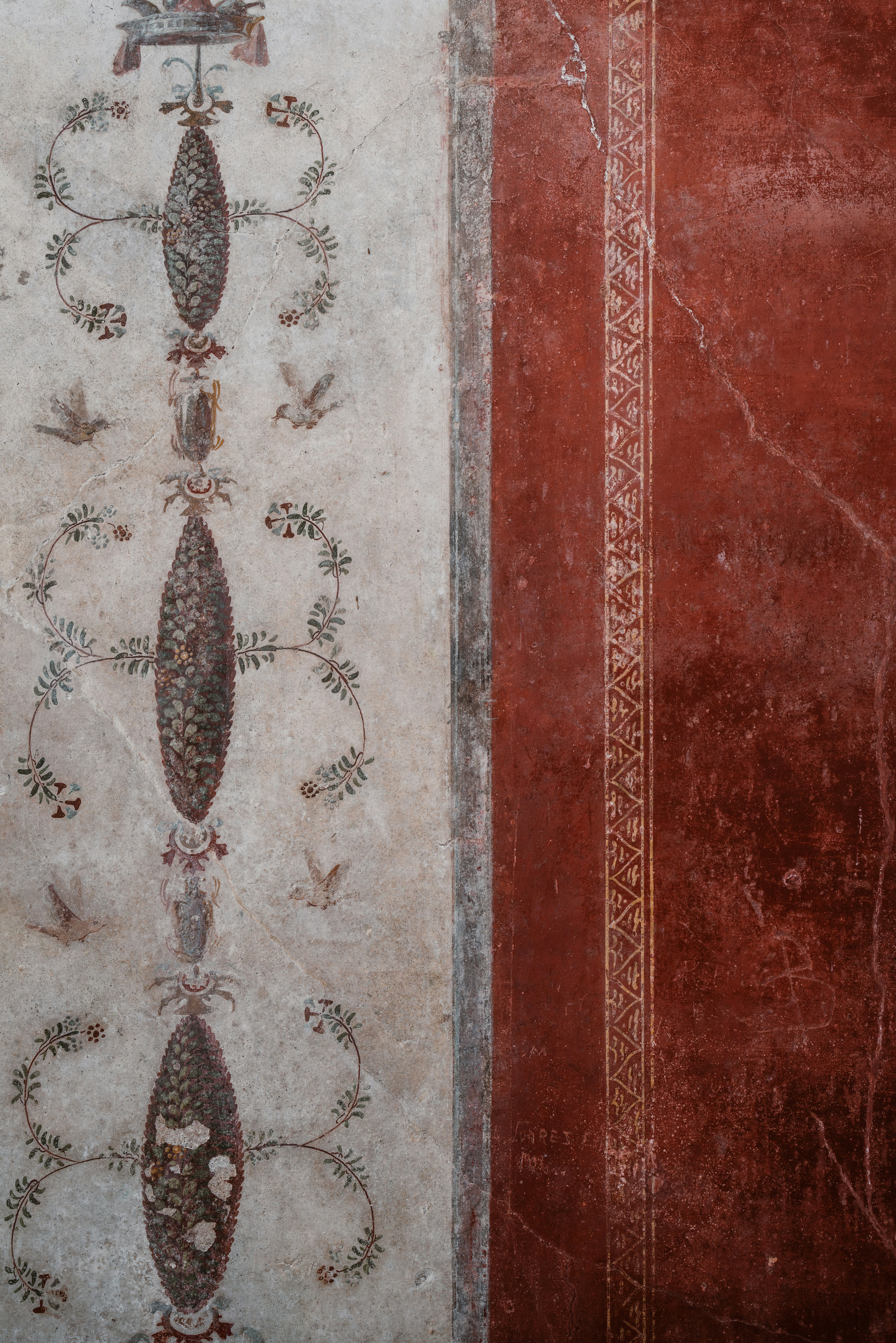 Ornamental Frieze in Aged Fresco: Repeating Elliptical Motifs along a Pale Panel