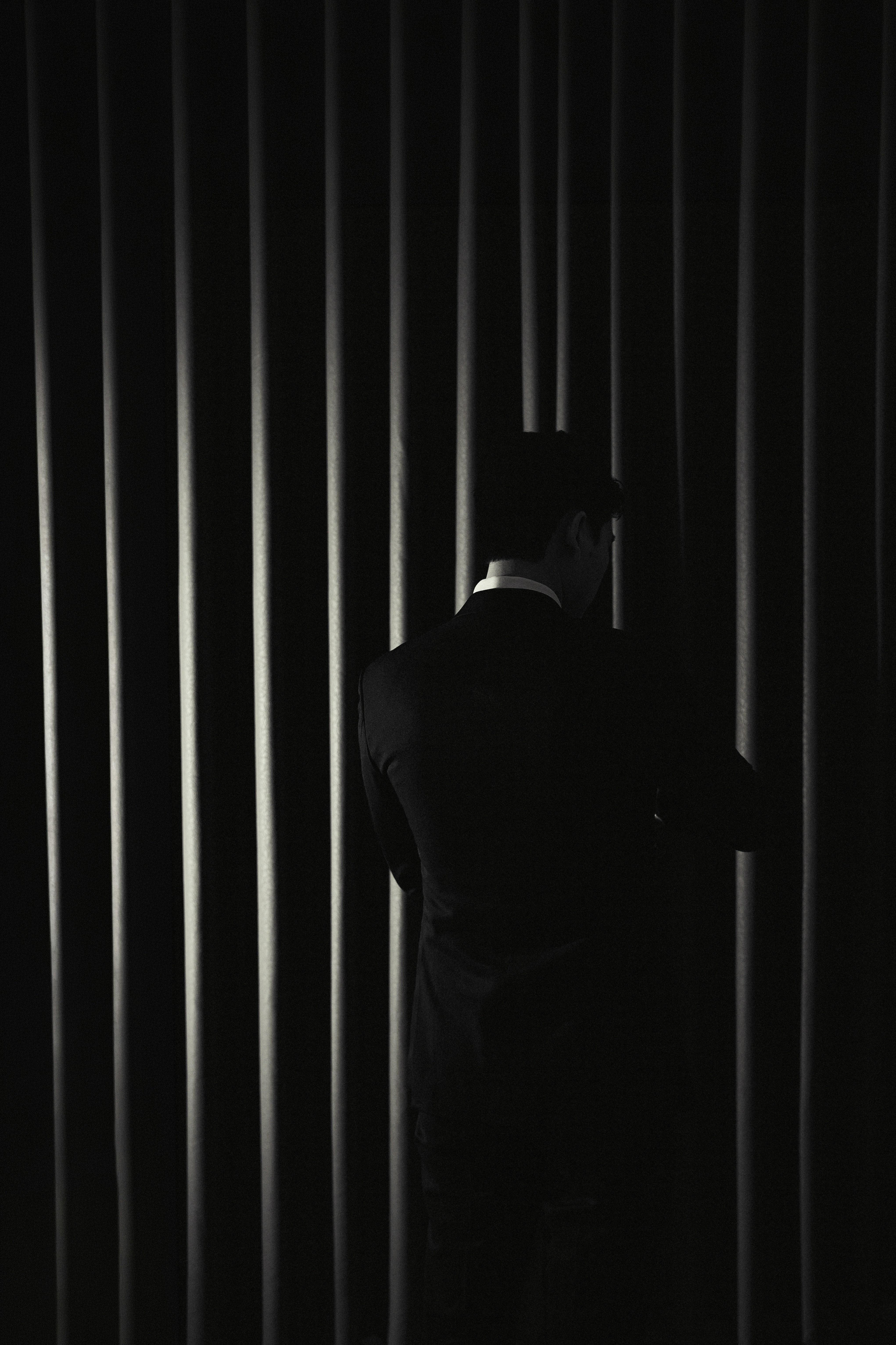 Shadowed silhouette in a corridor of vertical light