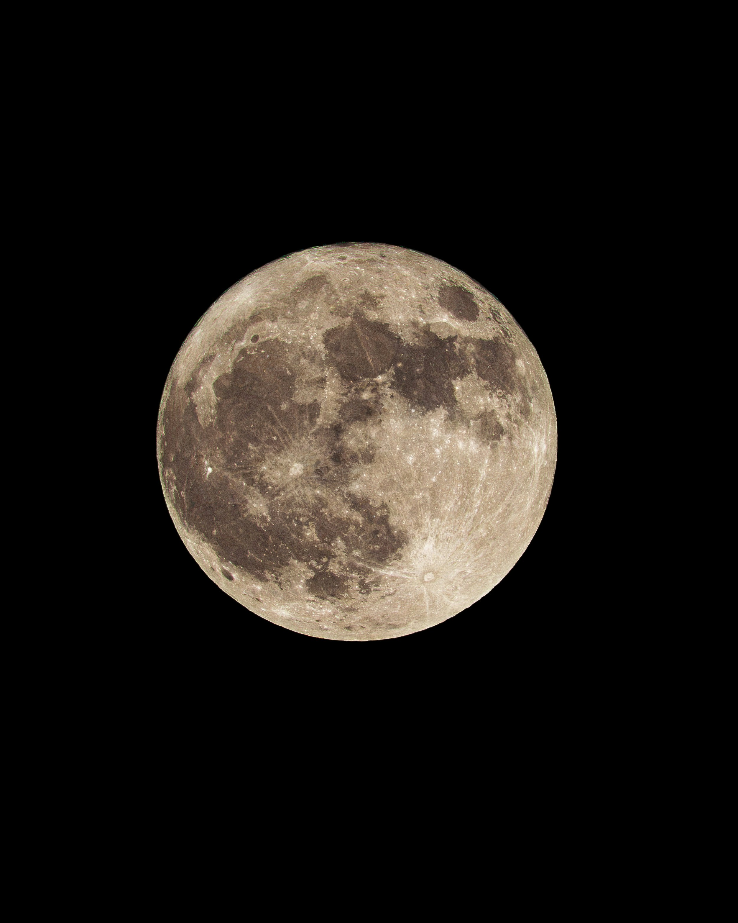 Cratered lunar disc against deep space, isolated on a black background showing nuanced surface textures.