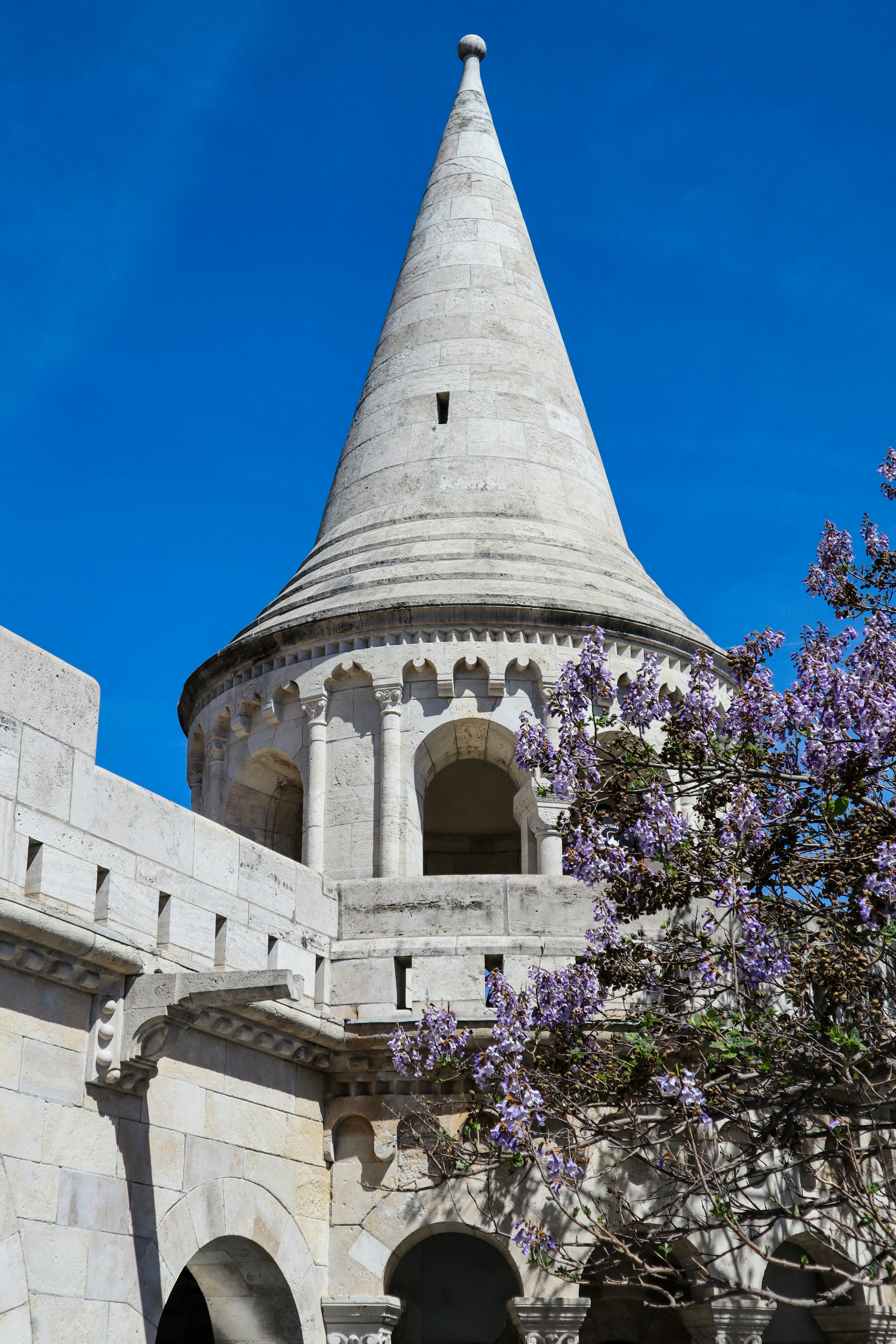 Stone Spire Against a Azure Sky with Lilac Bloom