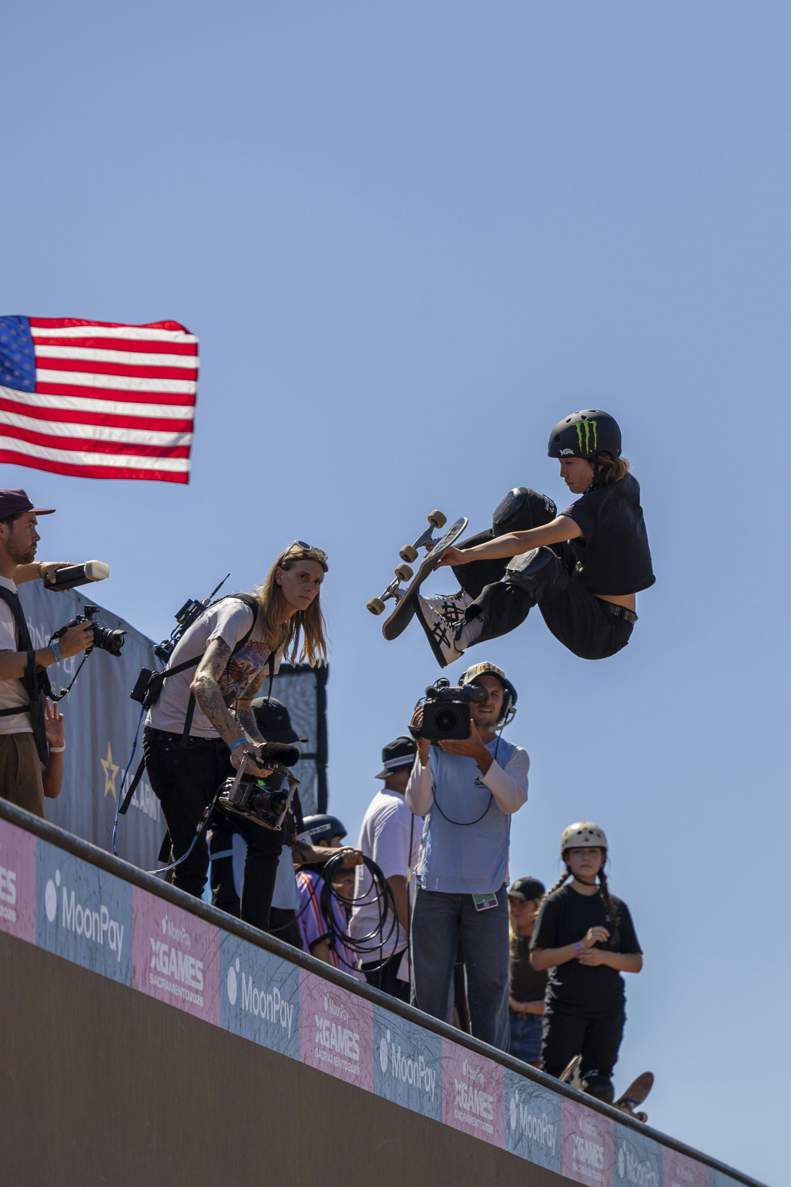 Airborne rider soars above the rails as the crowd watches