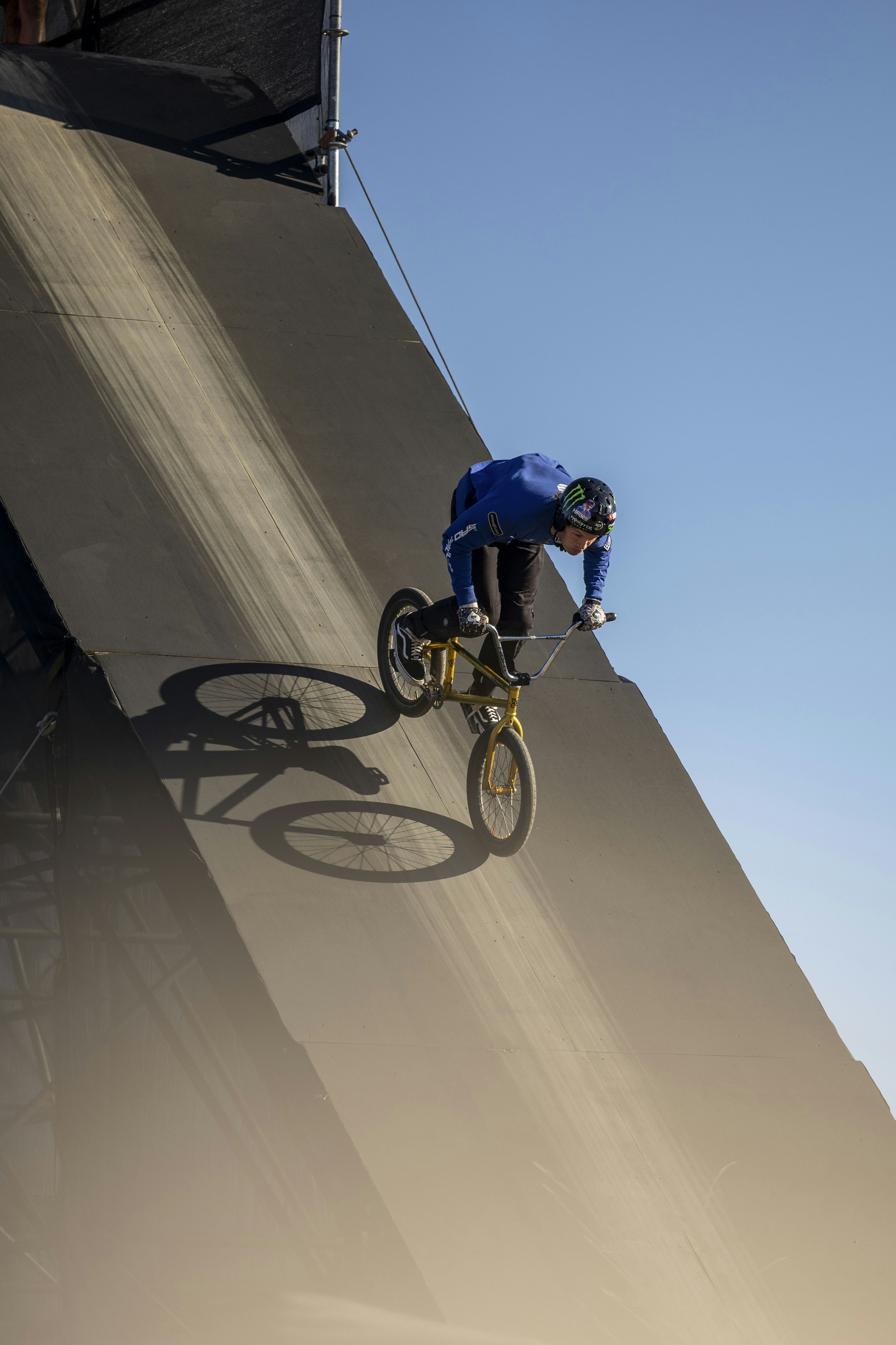 High-Stakes Descent: BMX Rider Sliding Down a Concrete Face